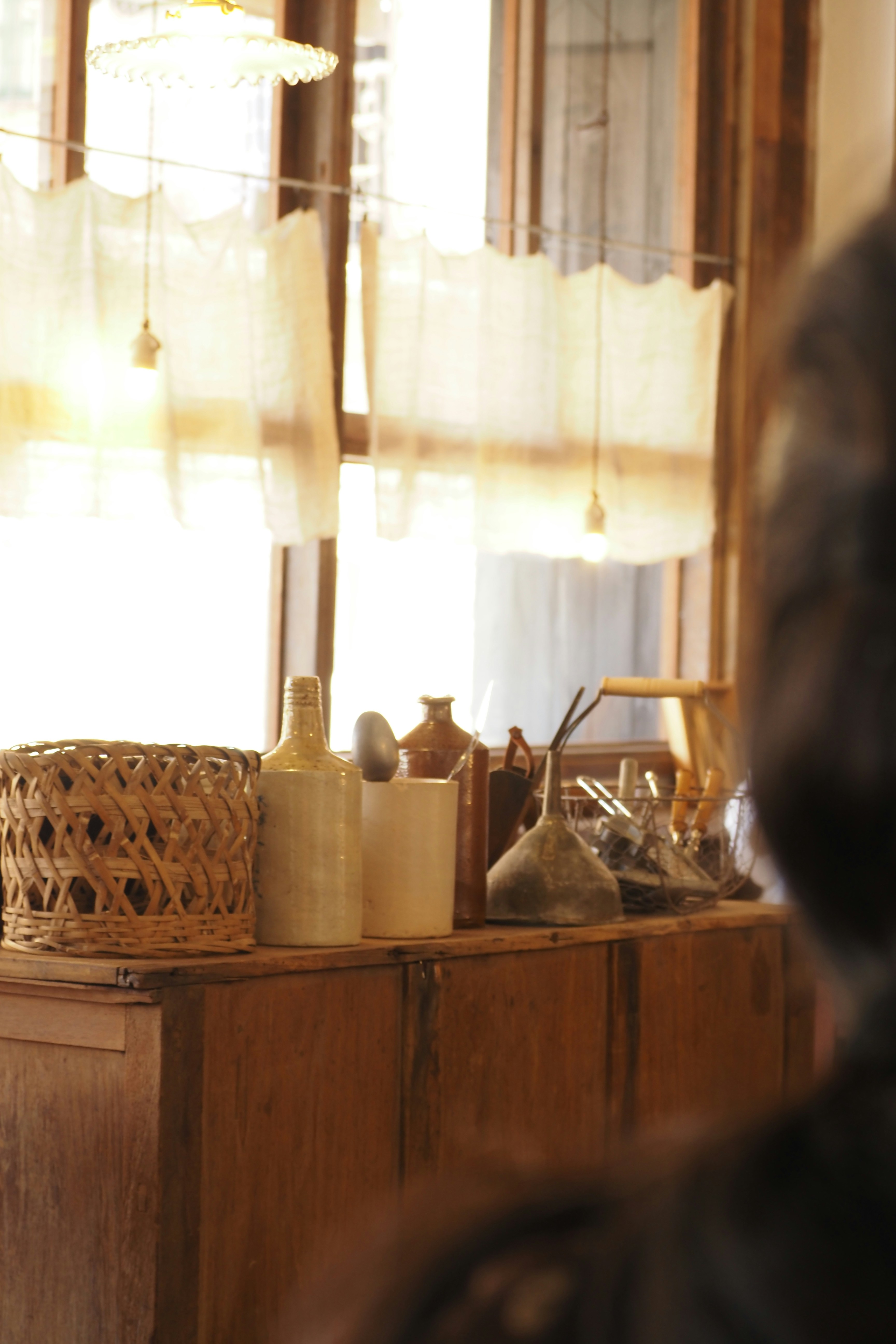 Still Life in Warm Light: Bottles and weave on a wooden cabinet