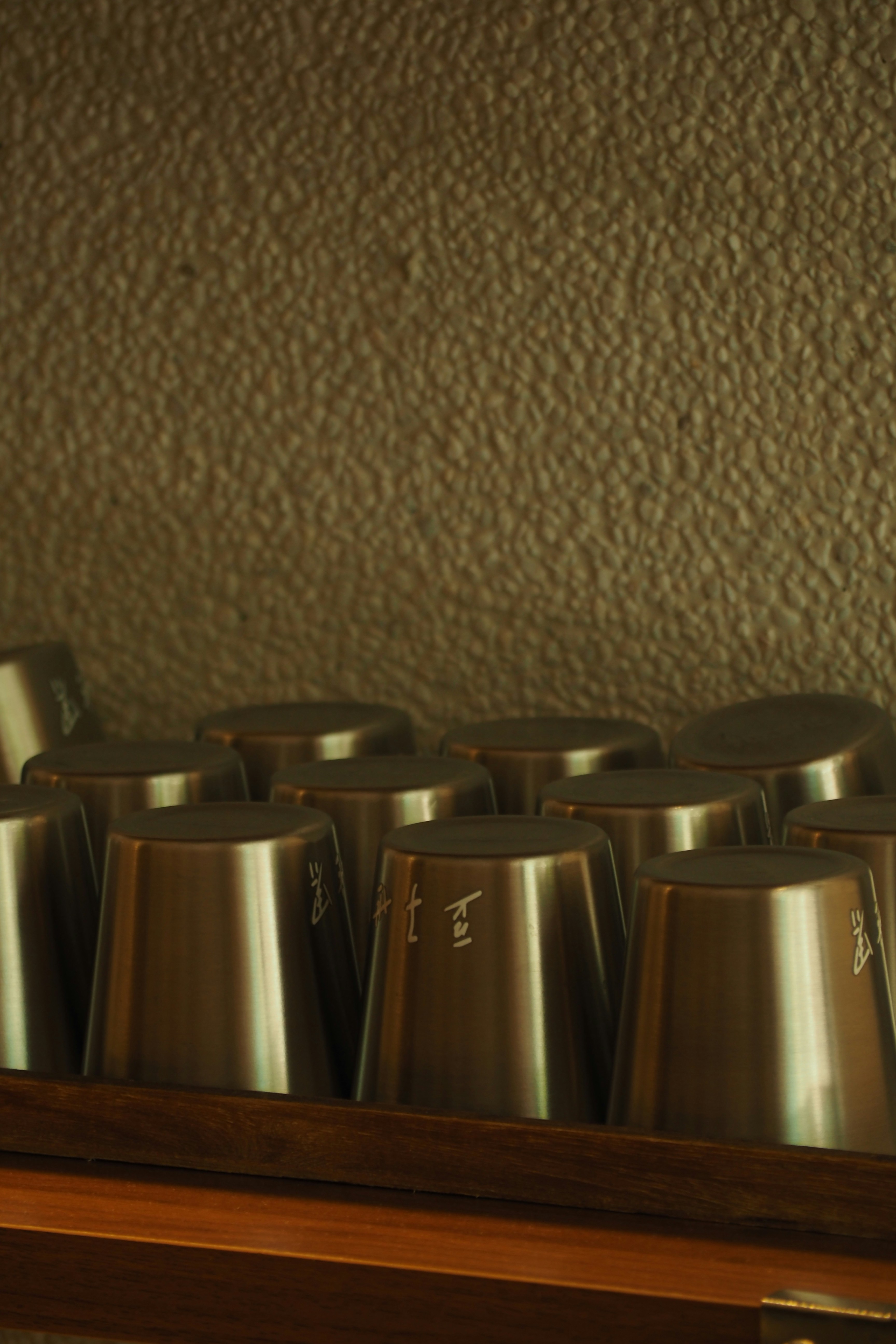 Metallic Echoes: Rows of Stainless Cups in Warm Studio Light