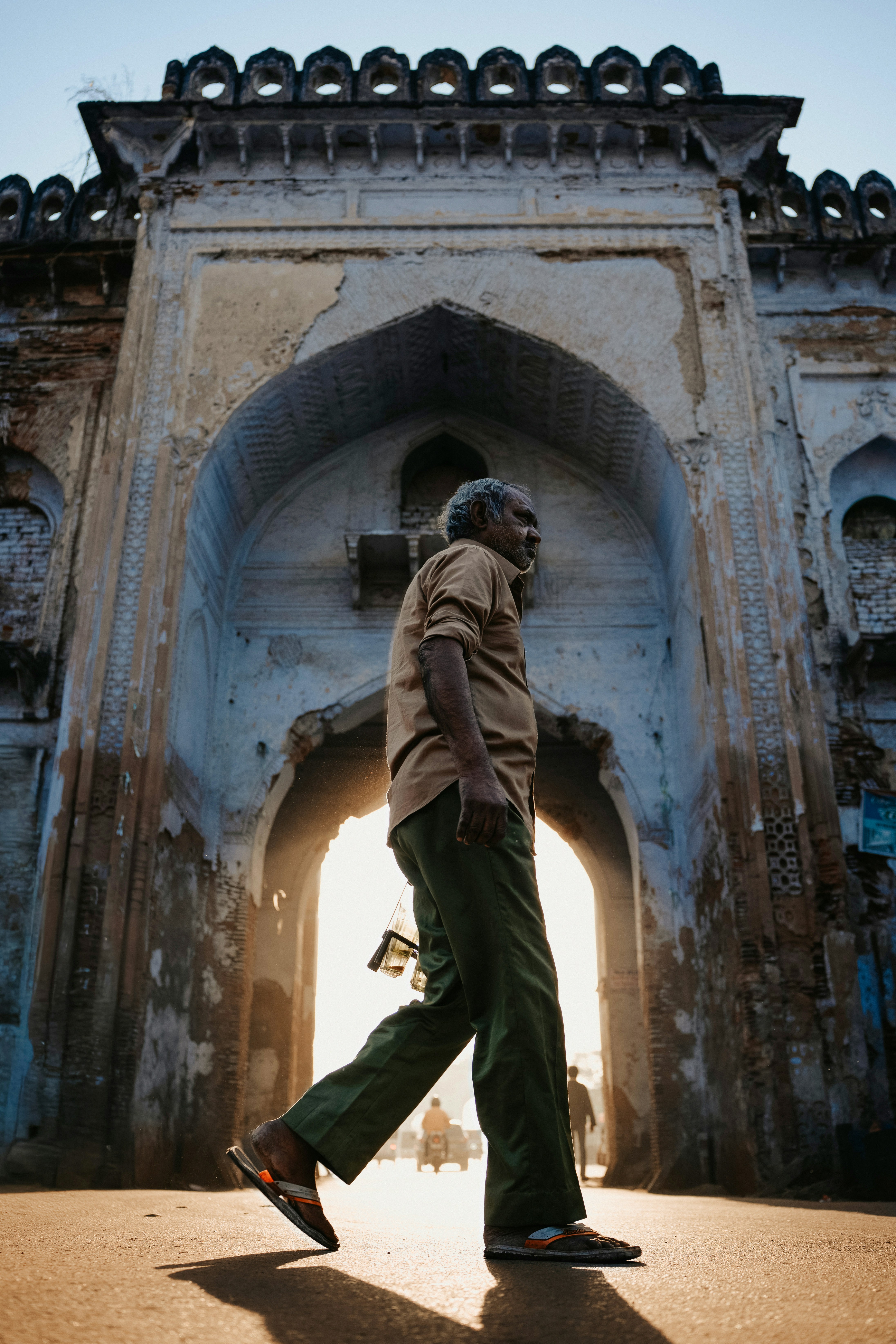 Footsteps Through the Gate: A Stranger Walks Beneath an Ancient Arch