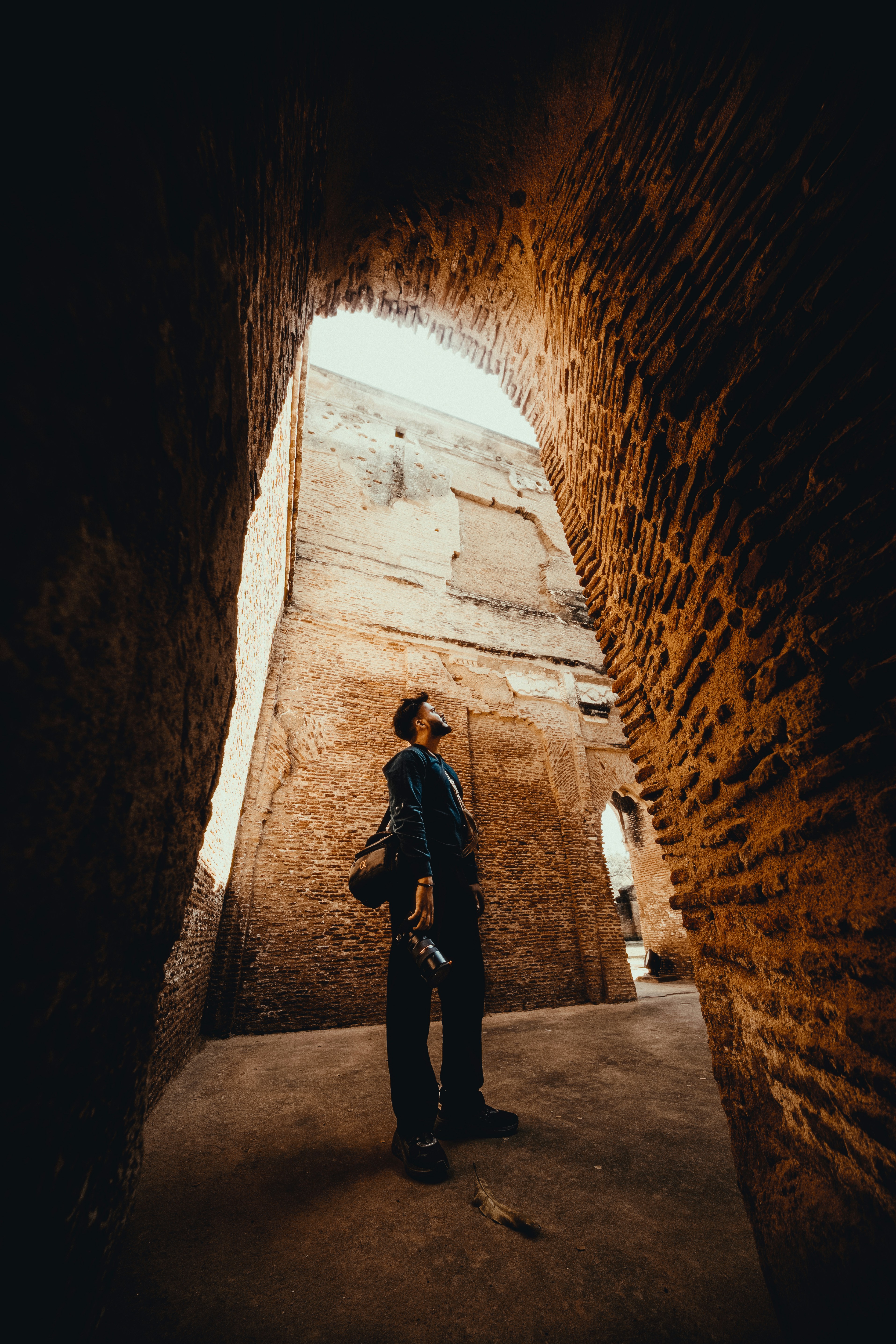 Traveler in a Sunlit Canyon: A Portrait Beneath Ancient Archways