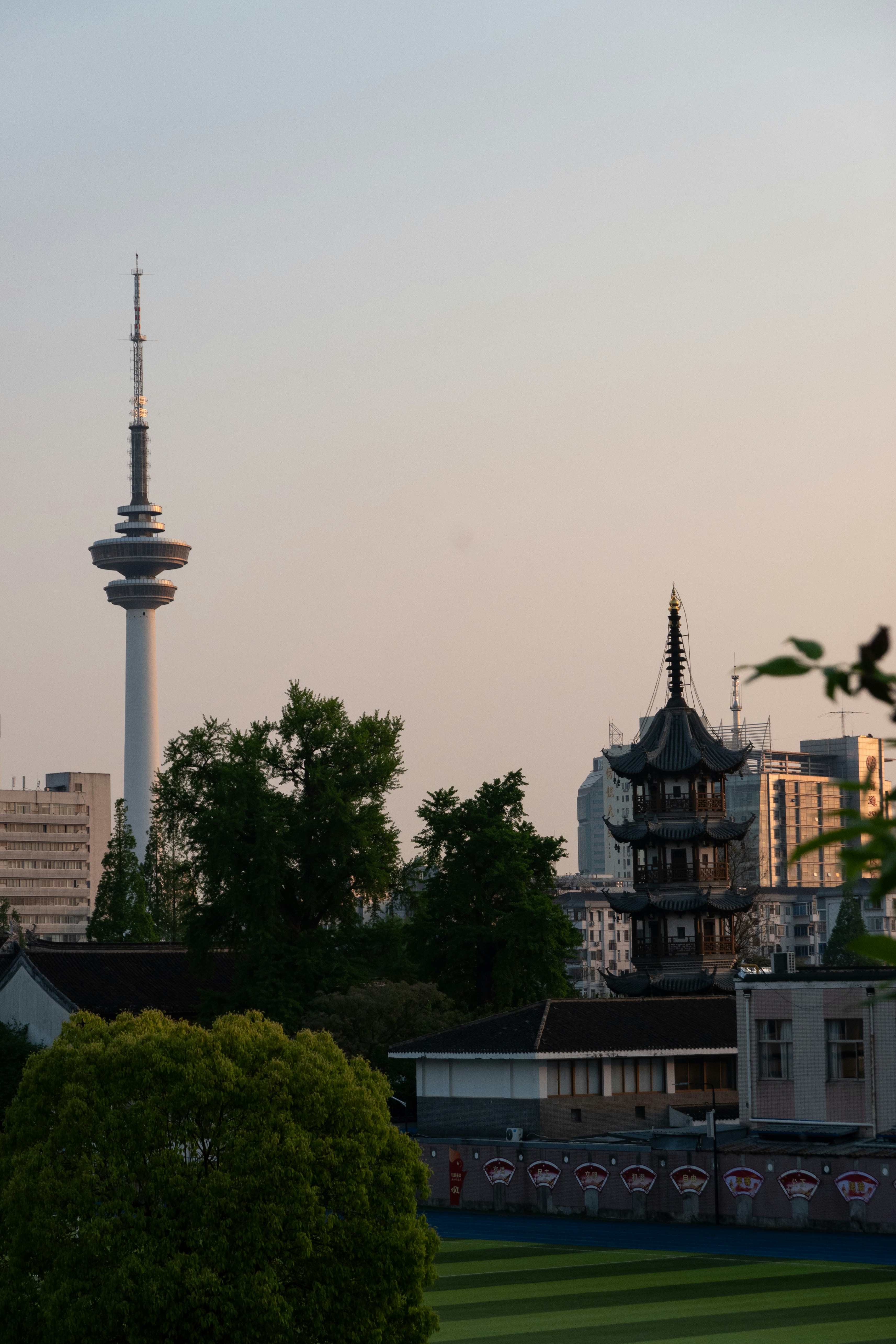 Twin Horizons: A Modern radio tower meets a traditional pagoda at dusk