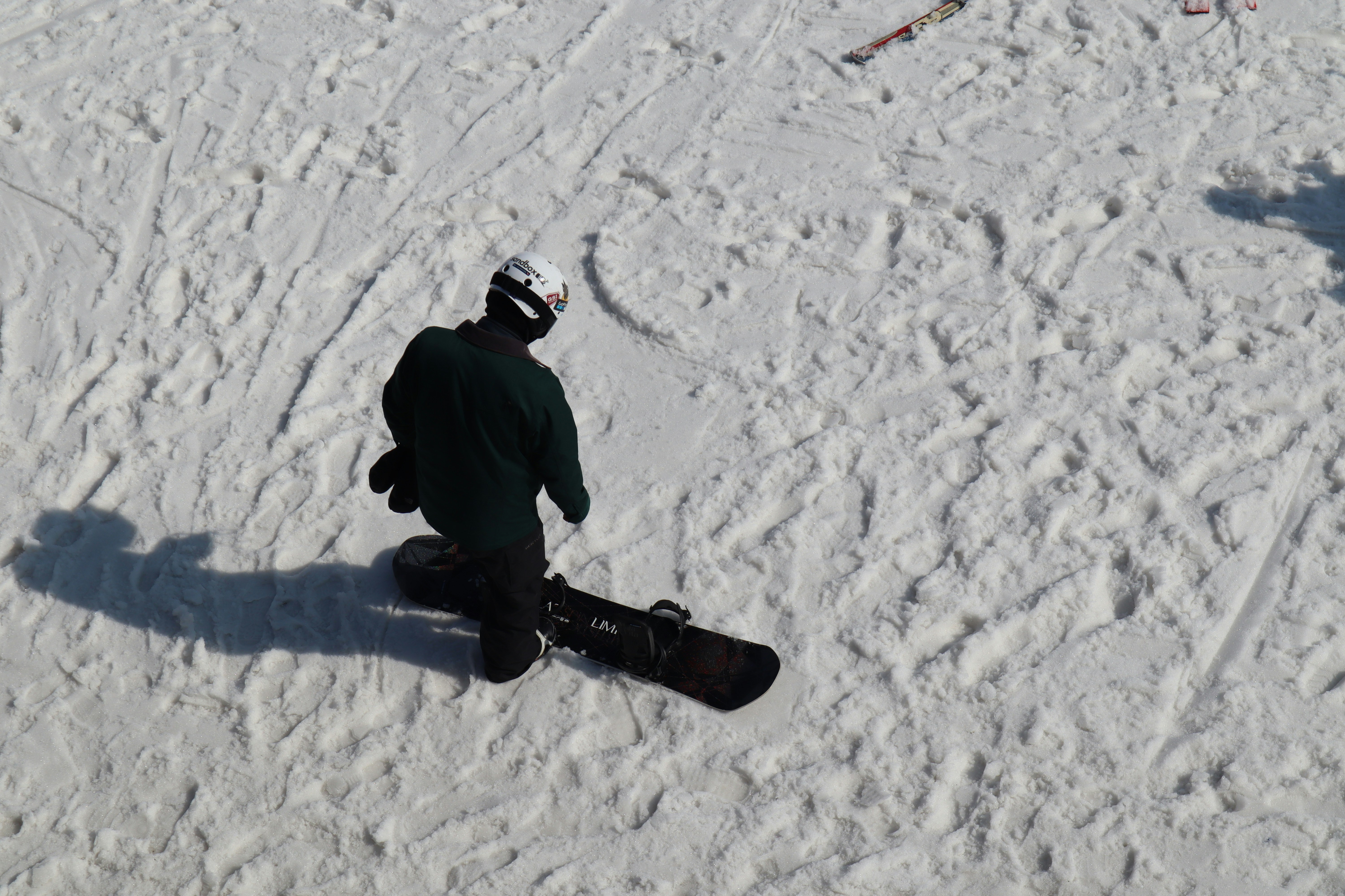 Snowboarder Takes a Pause: Sunglasses-Tinted Shadow Cast on Fresh Powder