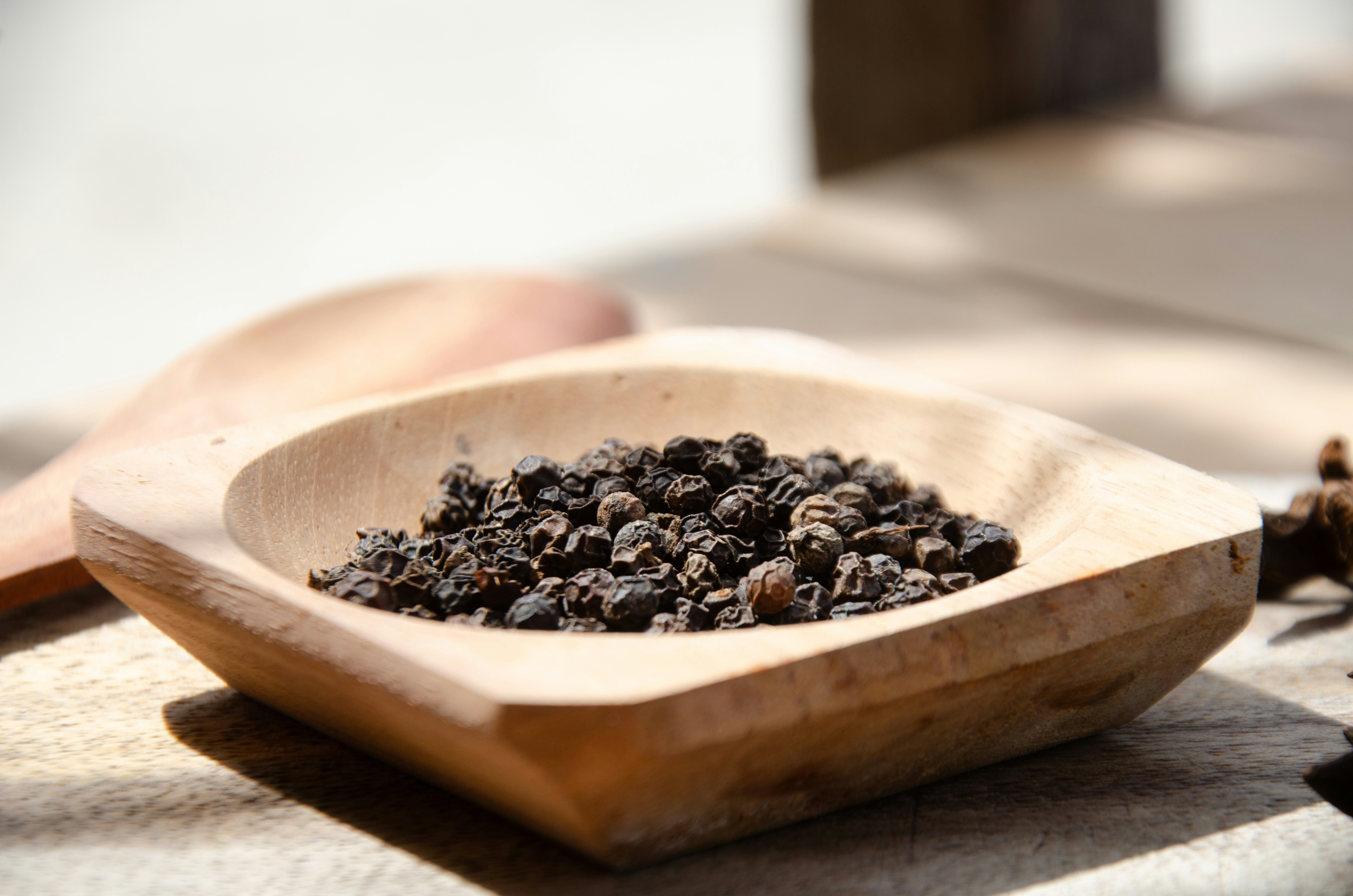 Sunlit Bowl of Dark Berries on a Weathered Wooden Table
