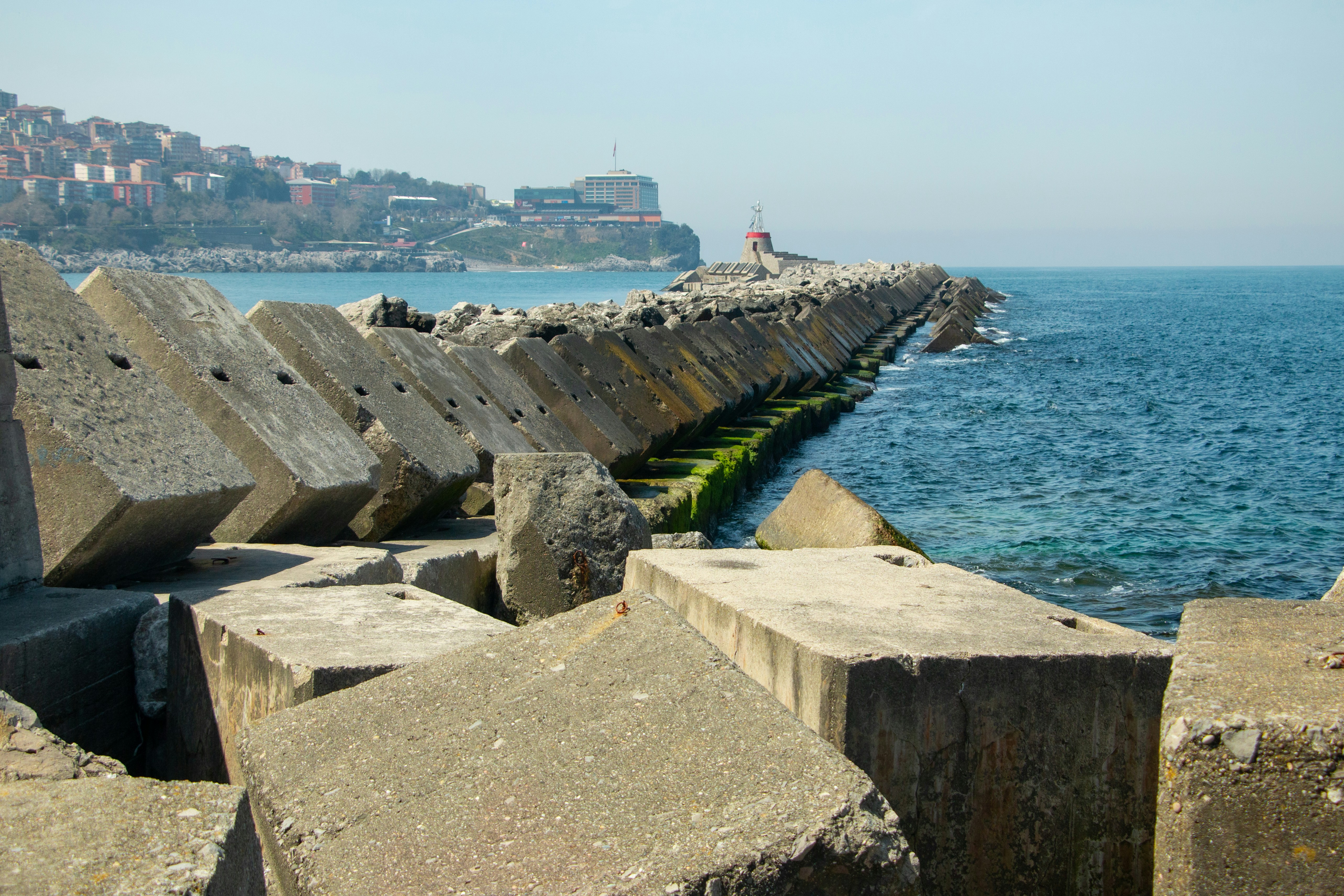 Stone Breakwater Reaching Toward a Coastal Lighthouse