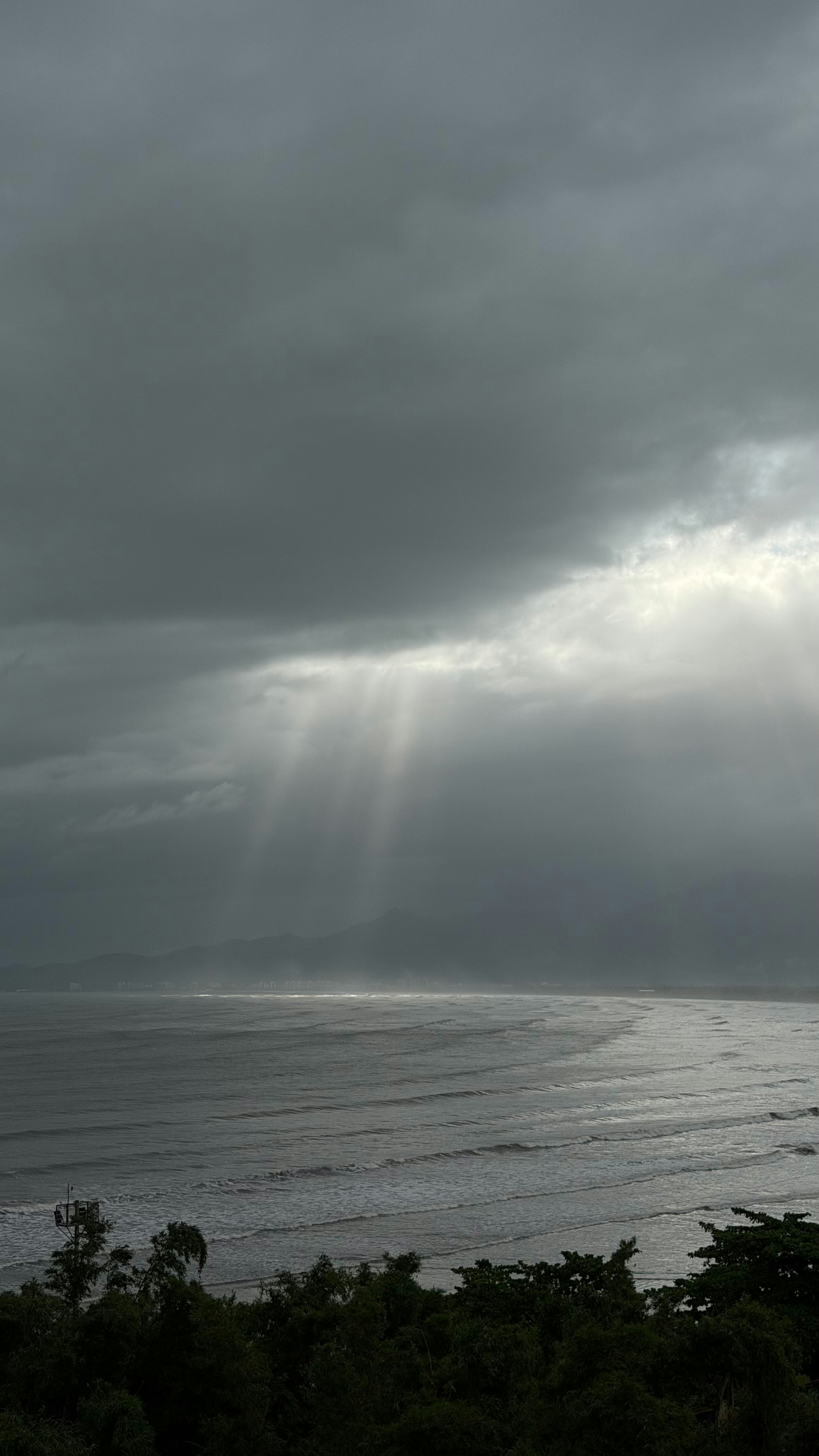 Rays Through a Break in the Clouds Over a Sea Cliff