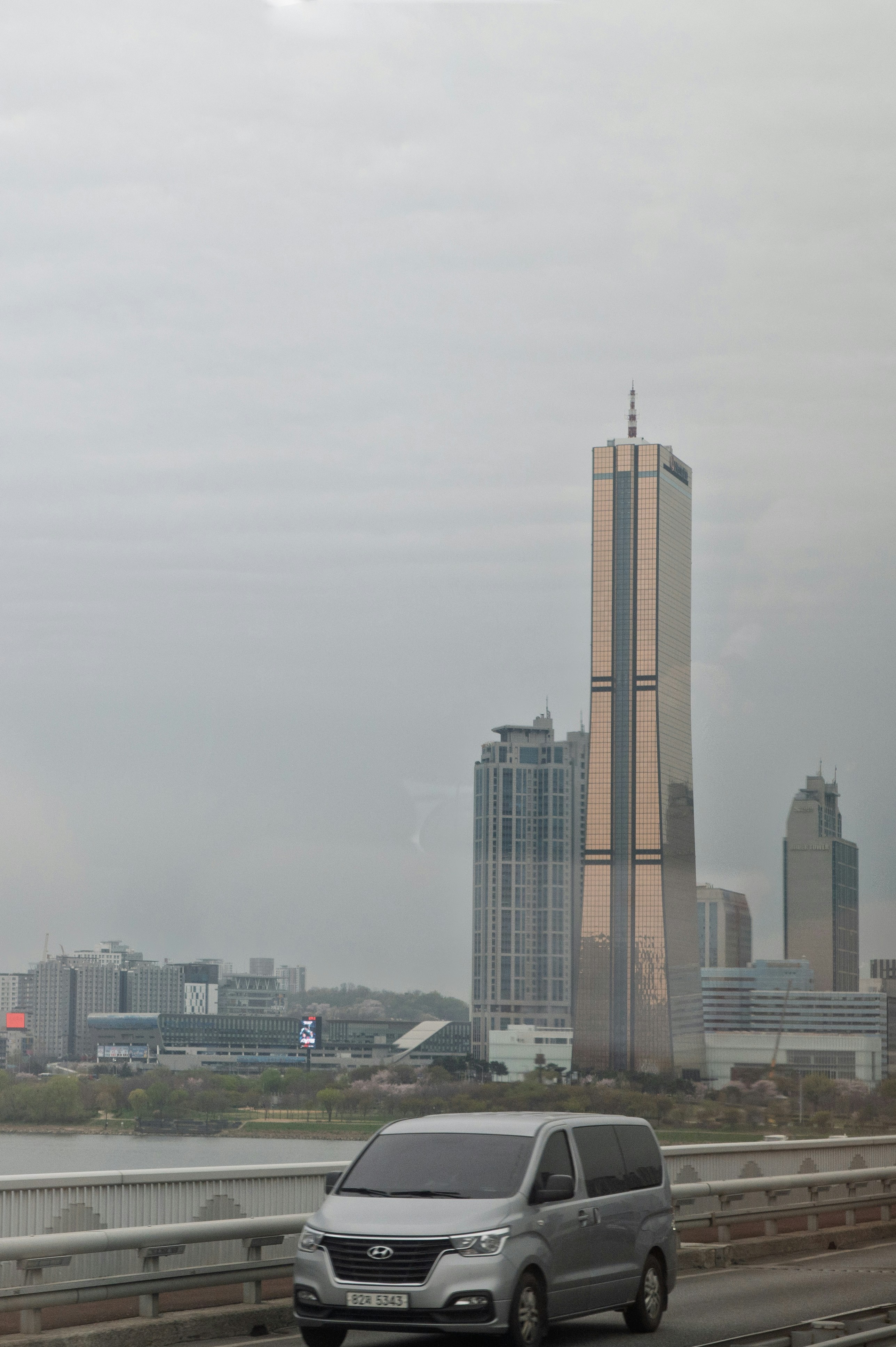 Towering Glass: A Cityscape ride beneath a cloudy sky