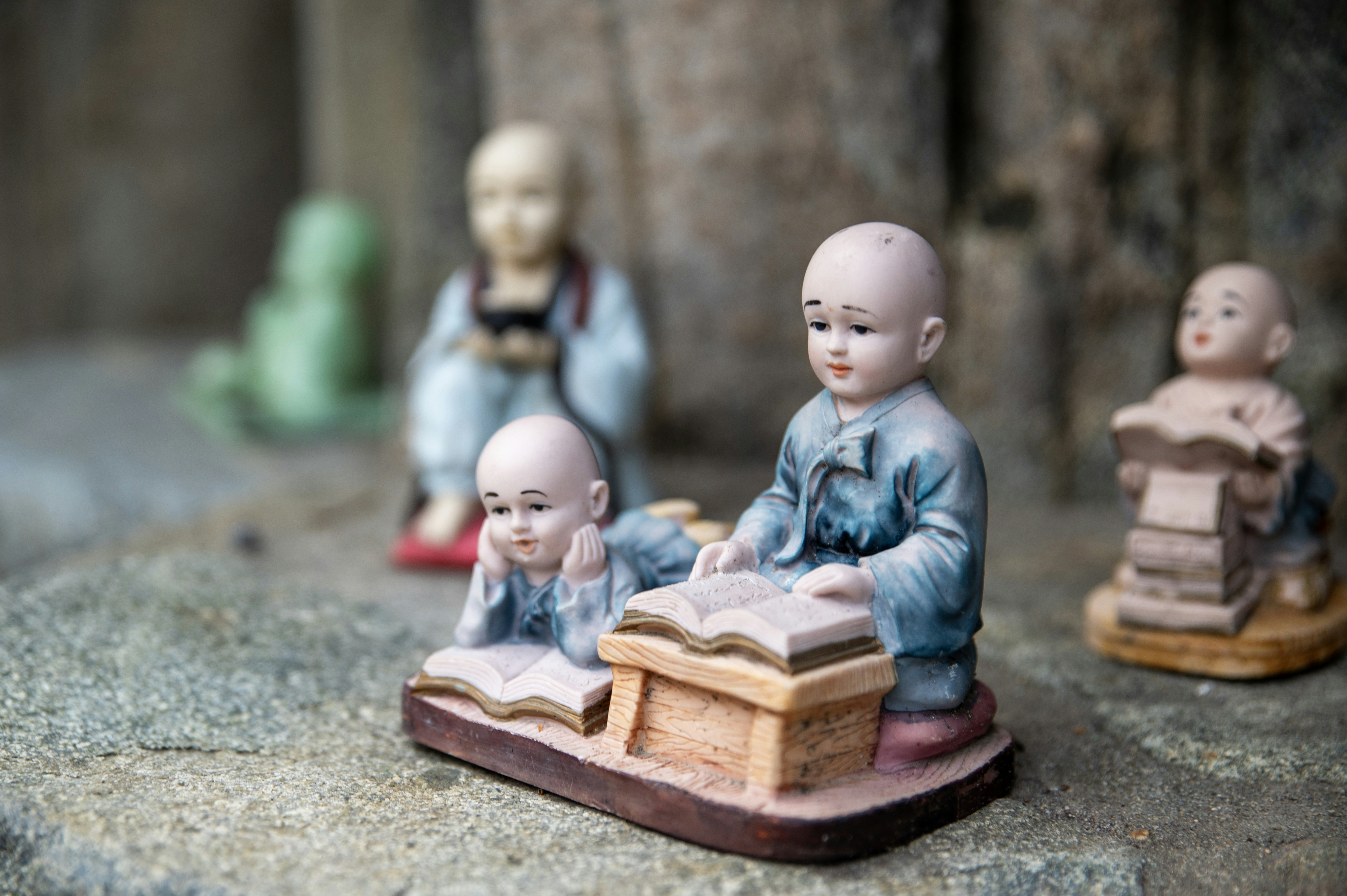 Serene temple caretakers: small figurines gathered around open books