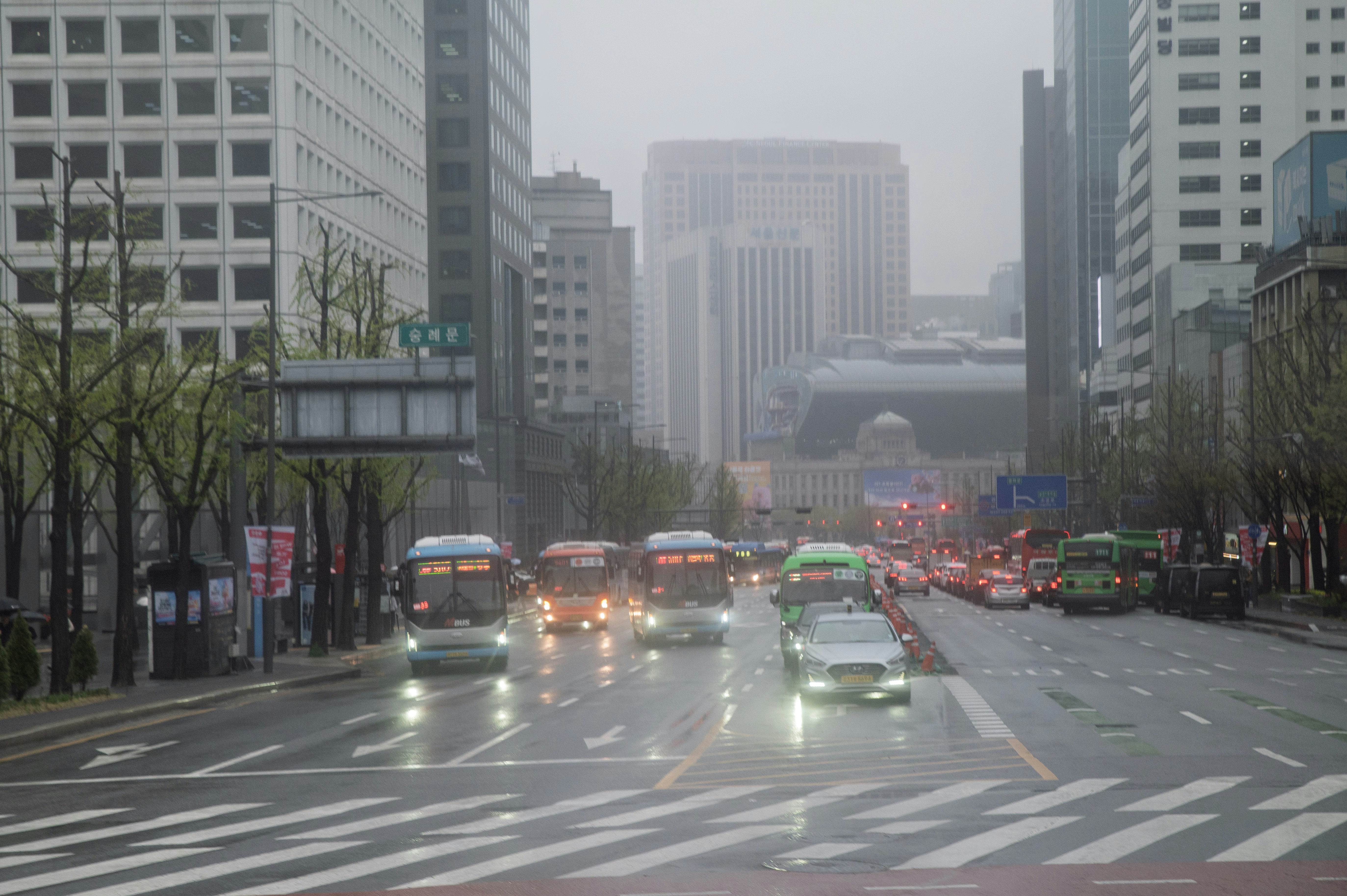 Urban Dawn in Motion: A Rain-Slicked Avenue Toward the Glass Canopy