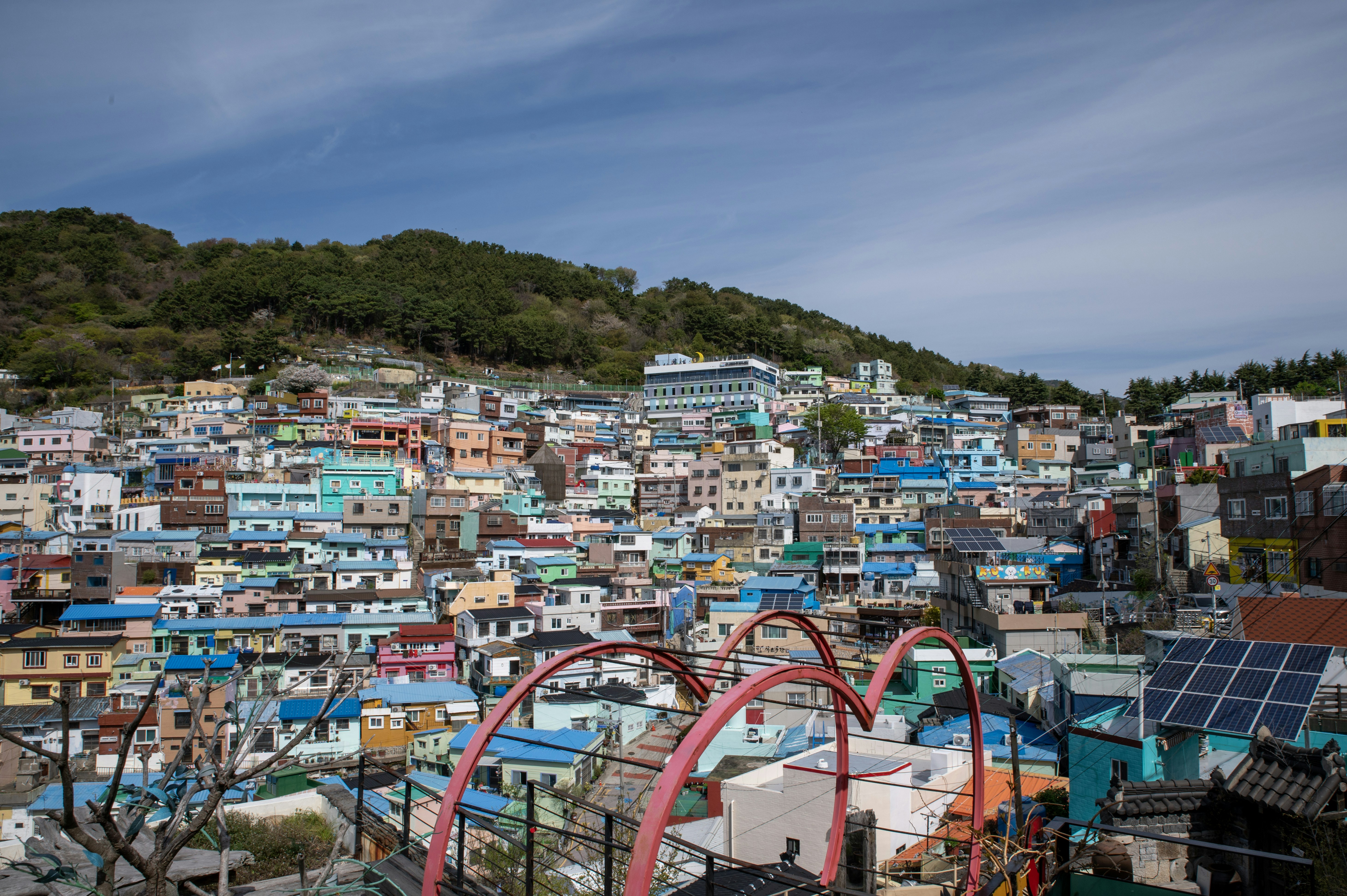Colorful hillside town under a blue sky framed by red arches