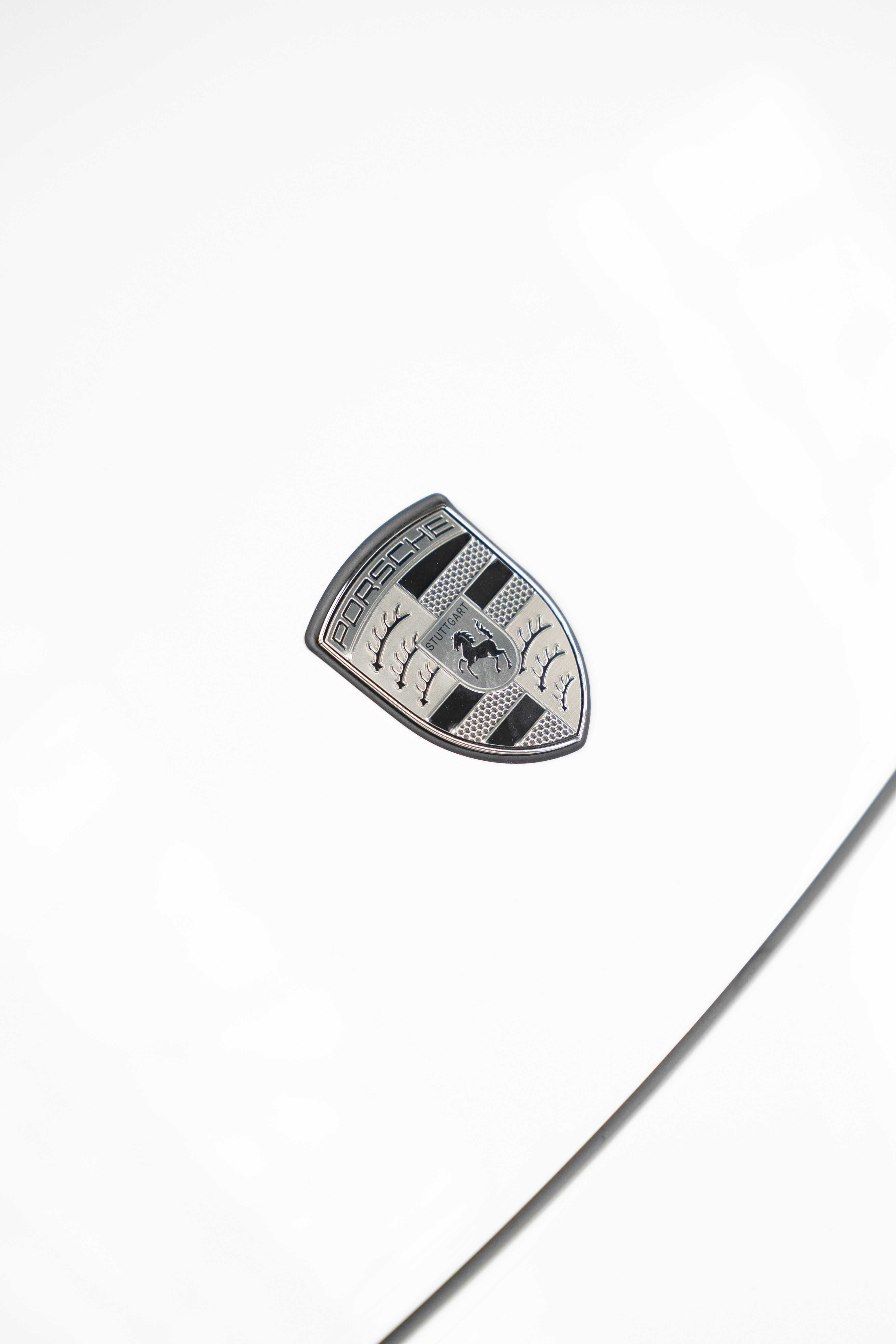 Shield of Precision: Porsche Crest Quietly Anchors a Minimal White Wake