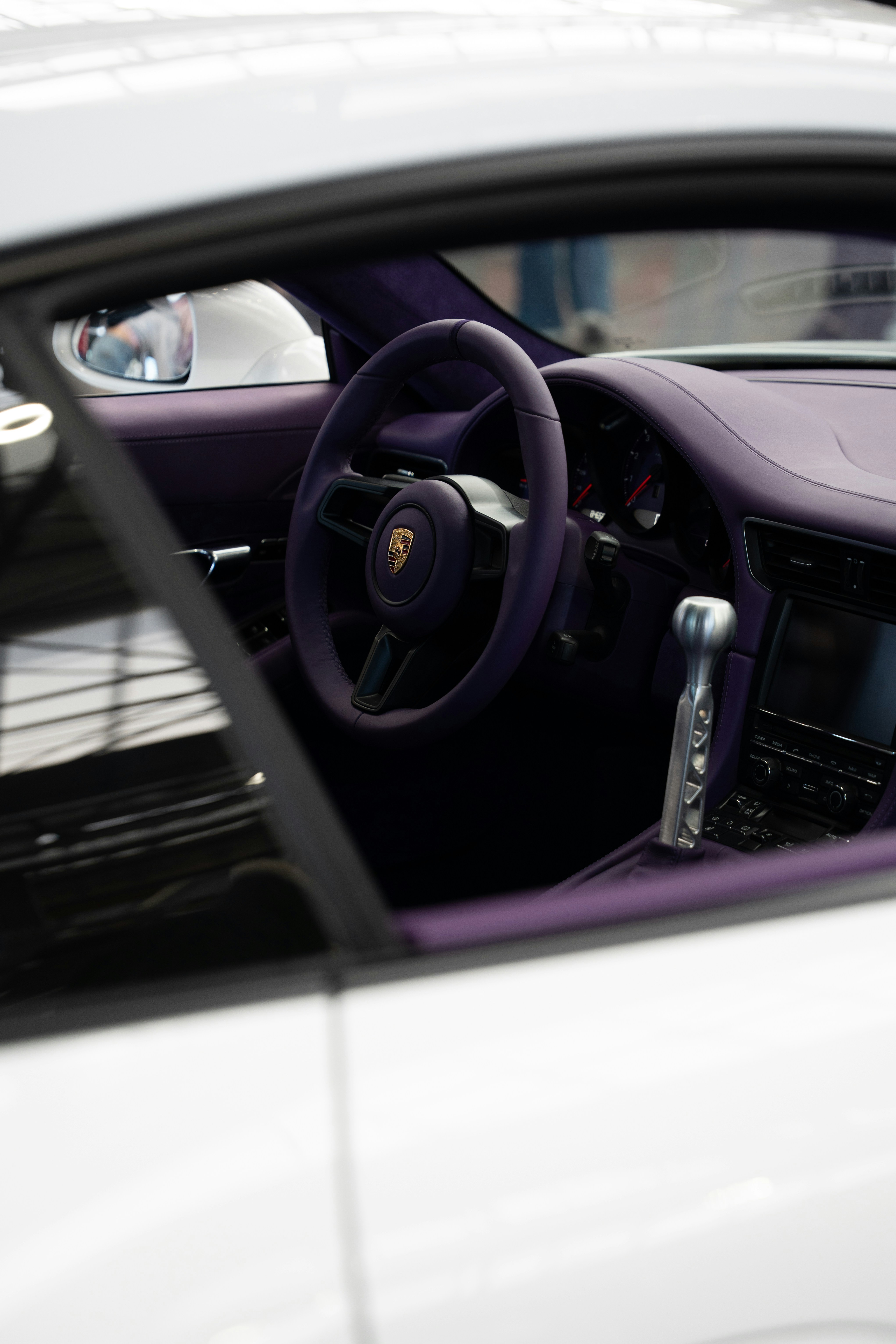 Purple cockpit: Porsche steering wheel and gear shifter through a car window