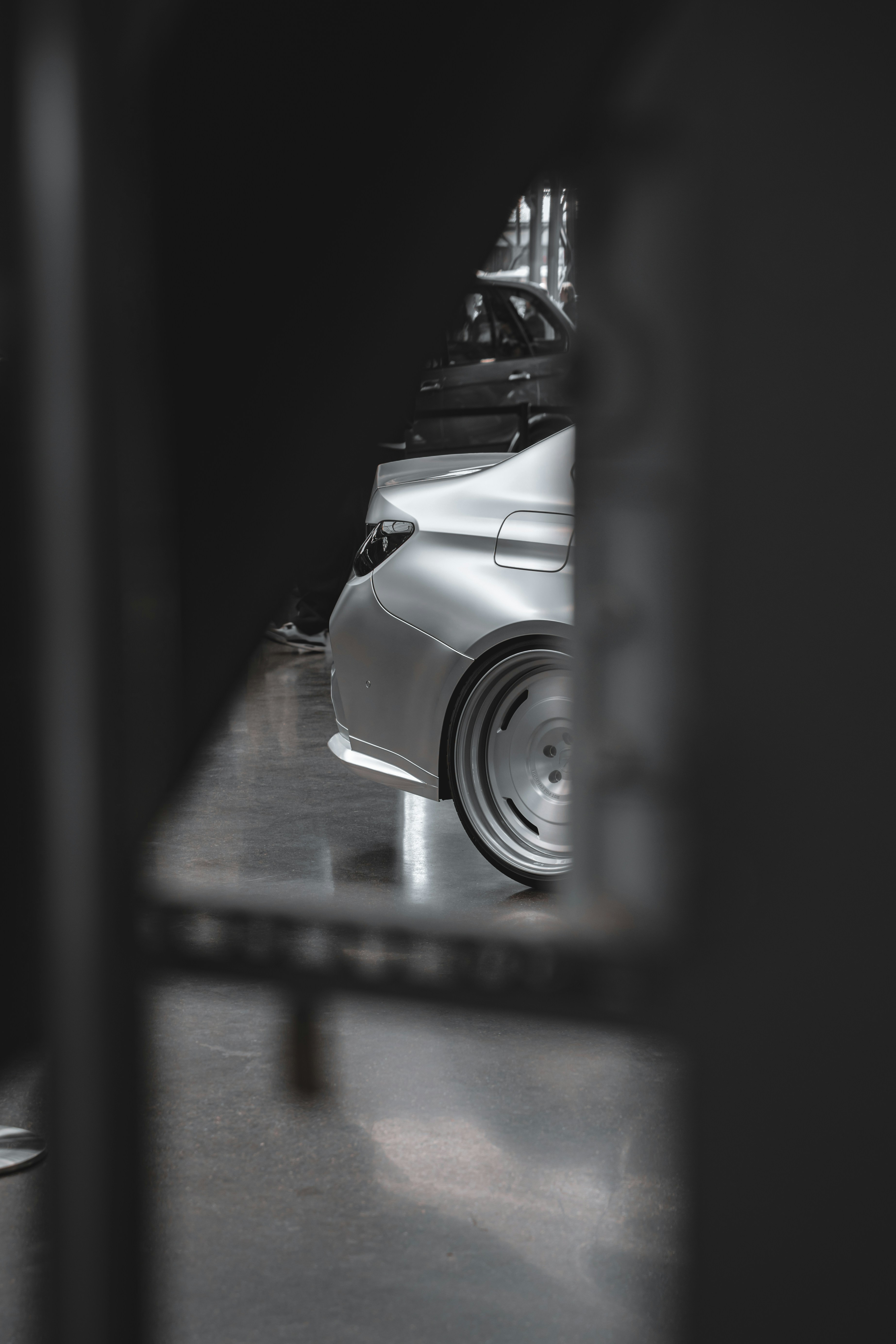Hidden Rims: A Silver Car Emerges Between Shadows