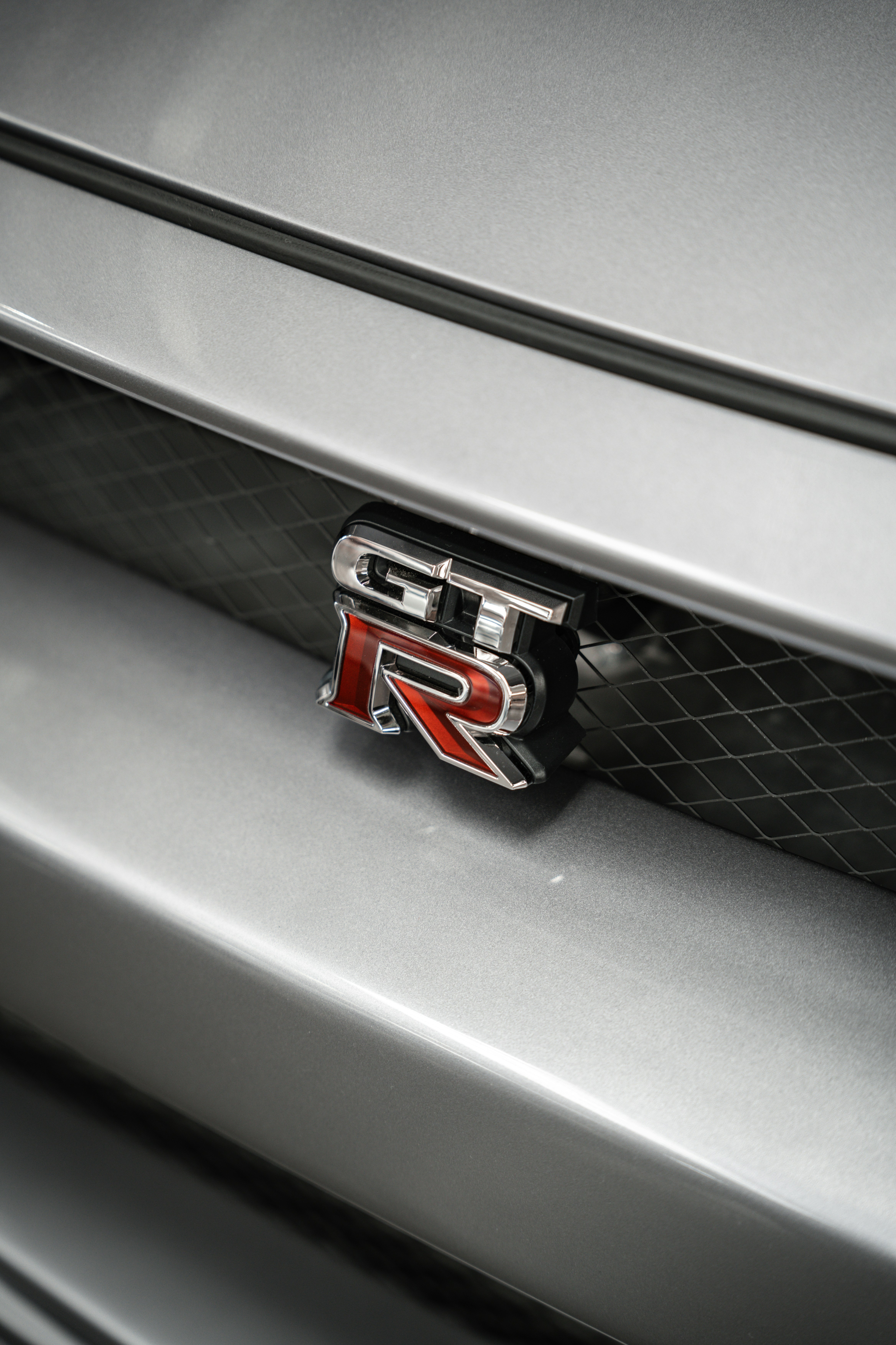 Nissan GT-R Emblem: Steel and Red in Quiet Steel