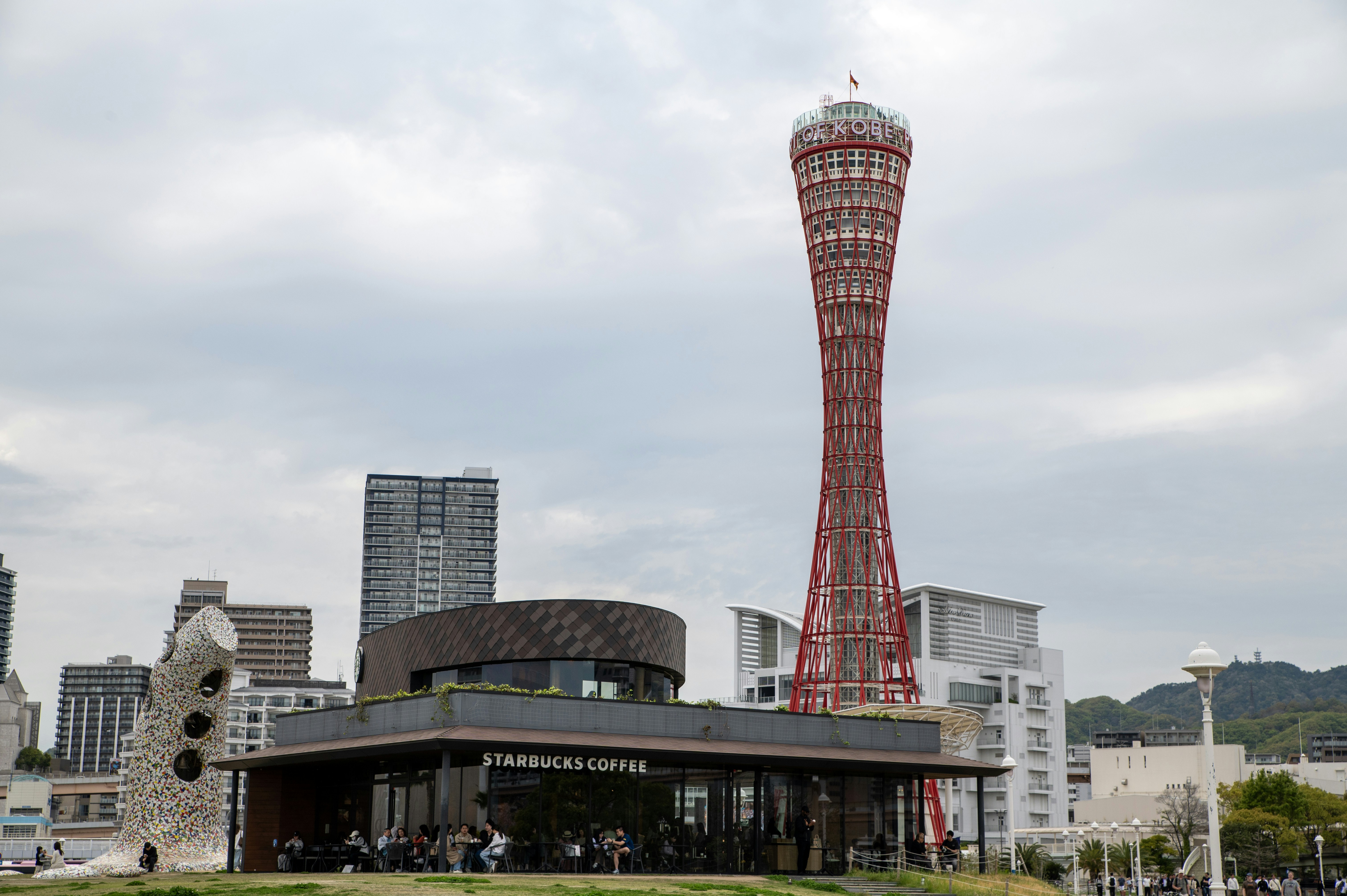 Red Tower and Modern Gallery: A Seaside Coffee Stop Under Cloudy Skies