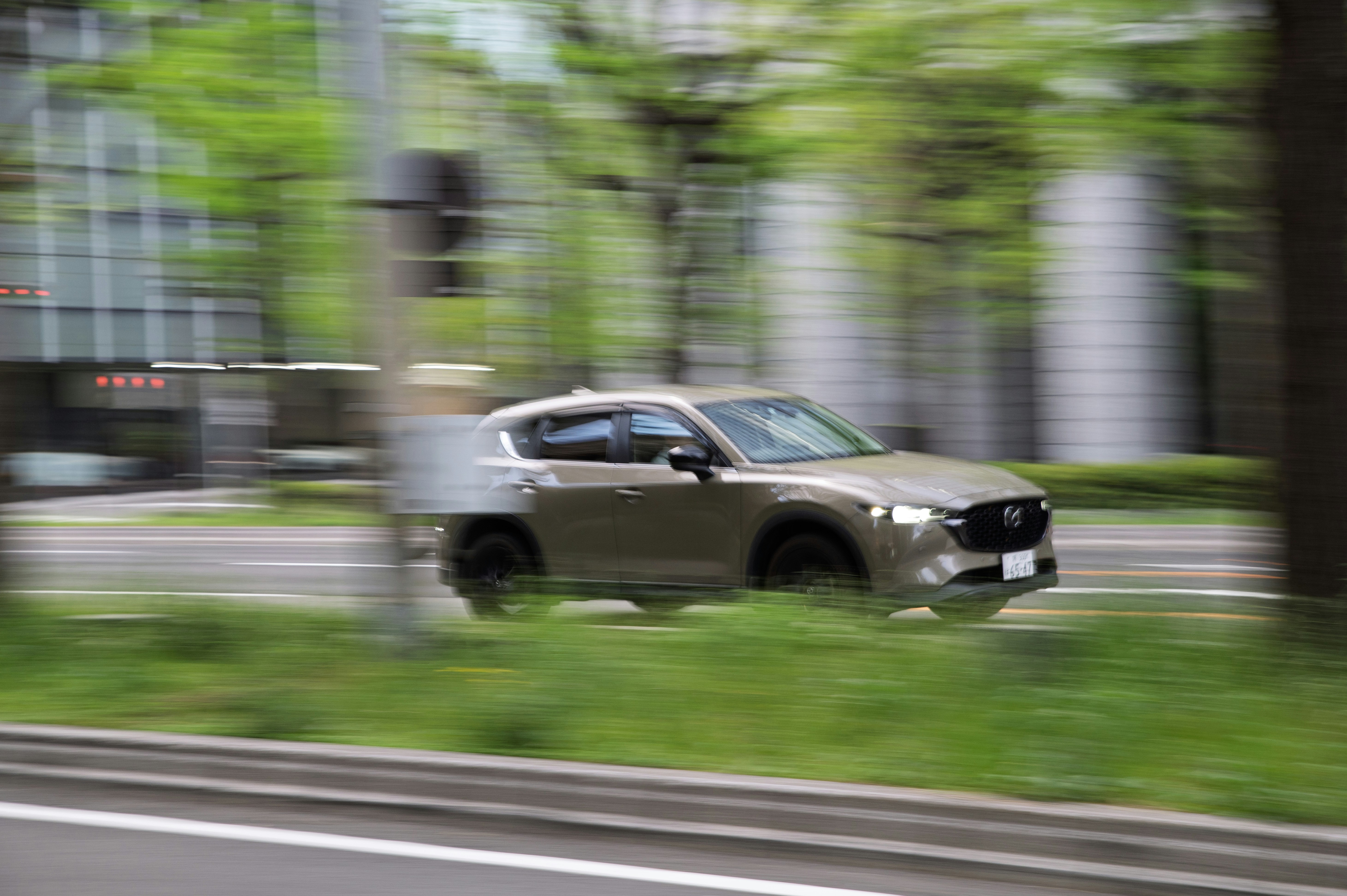 Momentum in Motion: Bronze SUV Rushing Through a Green Corridor