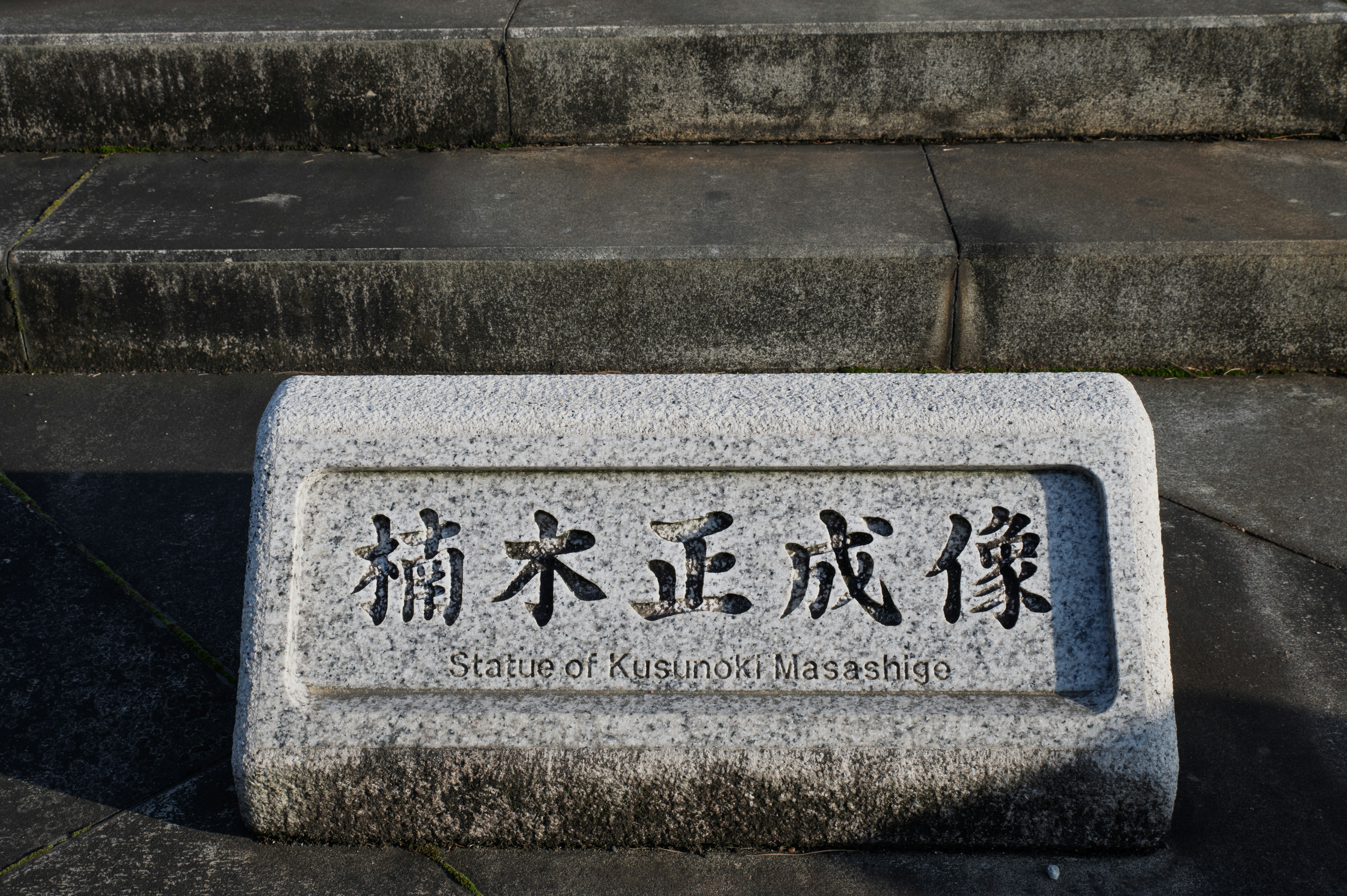 Stone pedestal with engraved characters and English subtitle