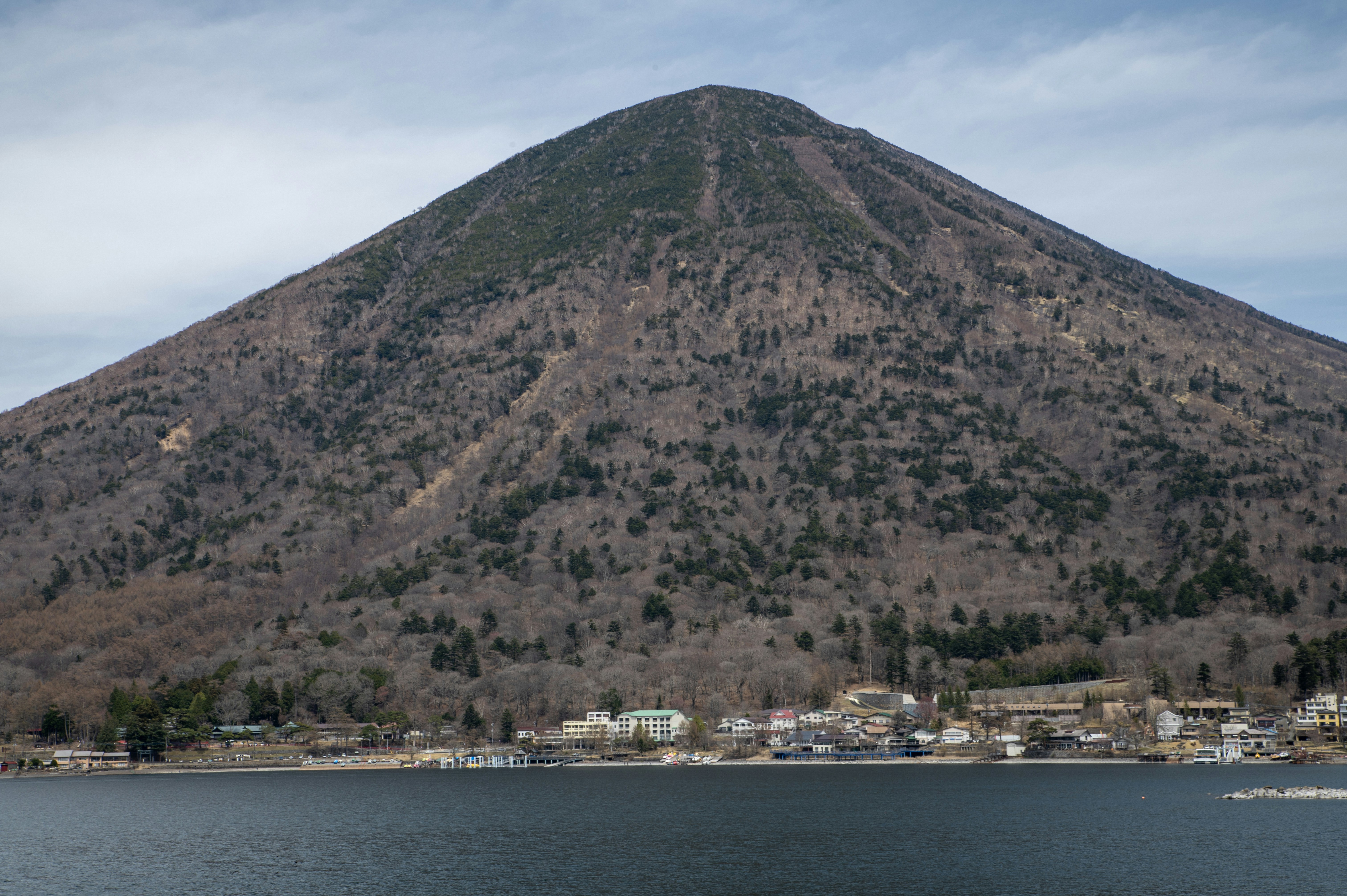 Lakeside Village Framed by a Quiet Volcanic Conical Peak