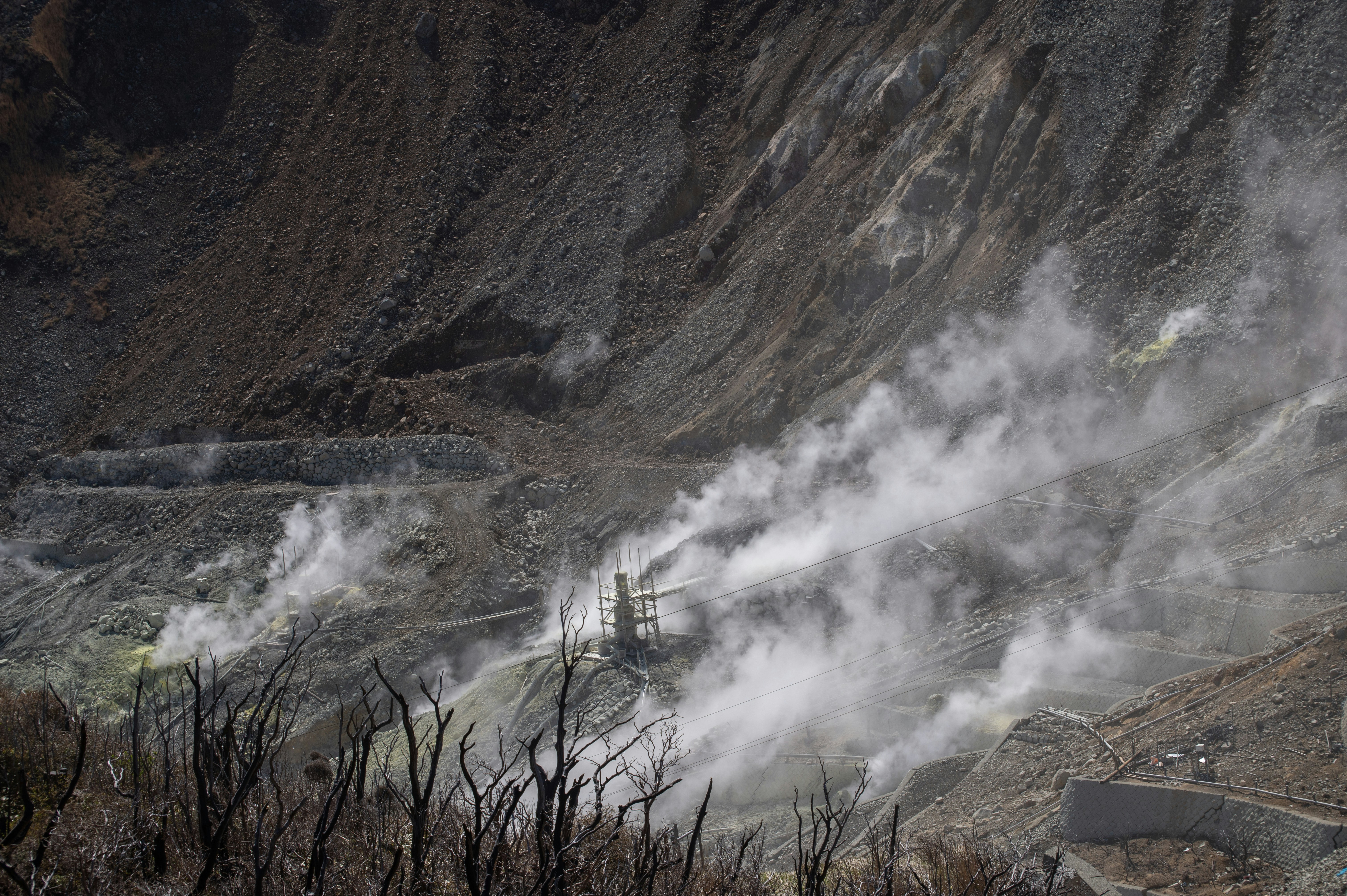 Steam Veil over Volcanic Quarry: Industrial Exhaust in a Barren Landscape
