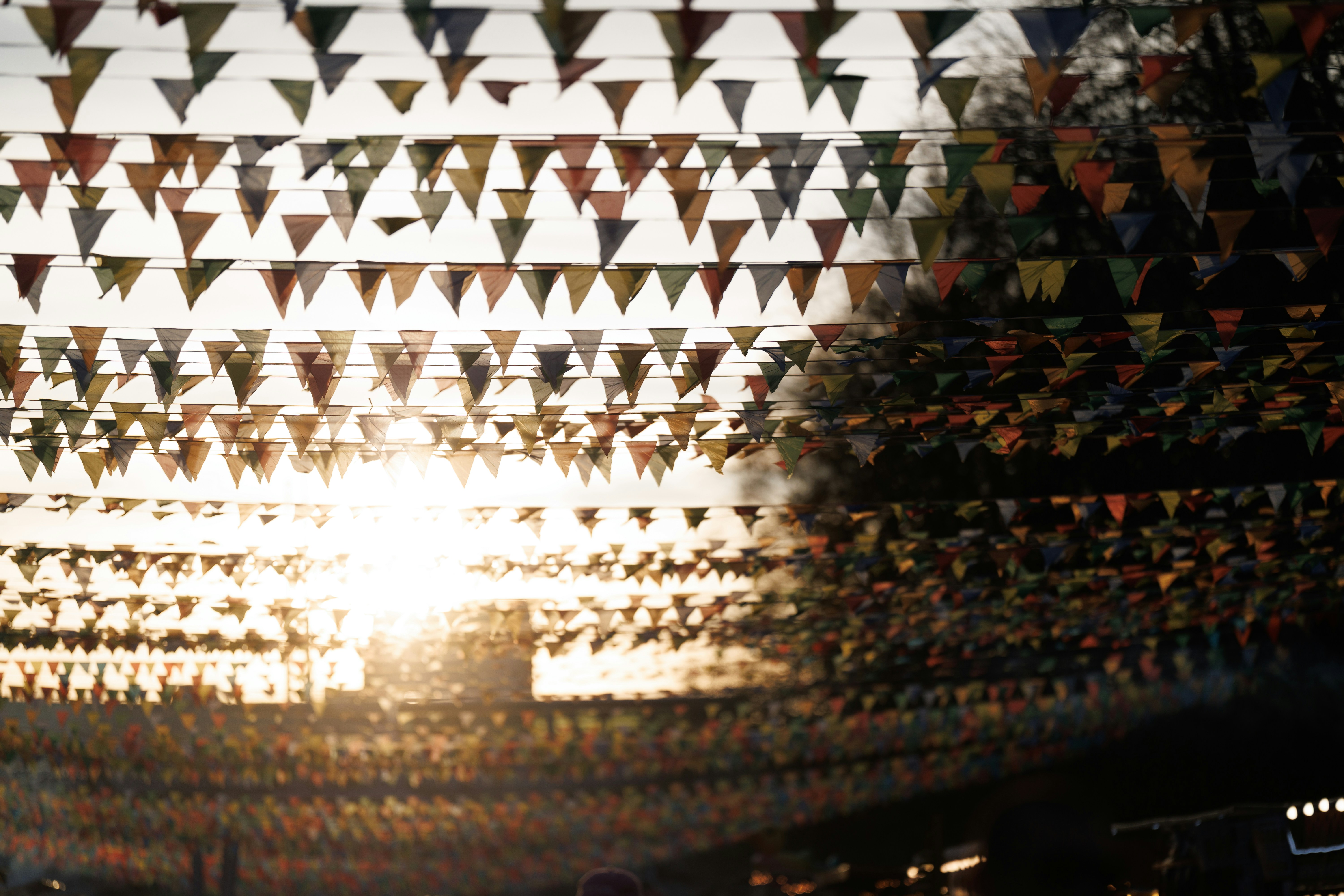 Sunlit Chaos of Colorful Flags in an Open Roofed Square