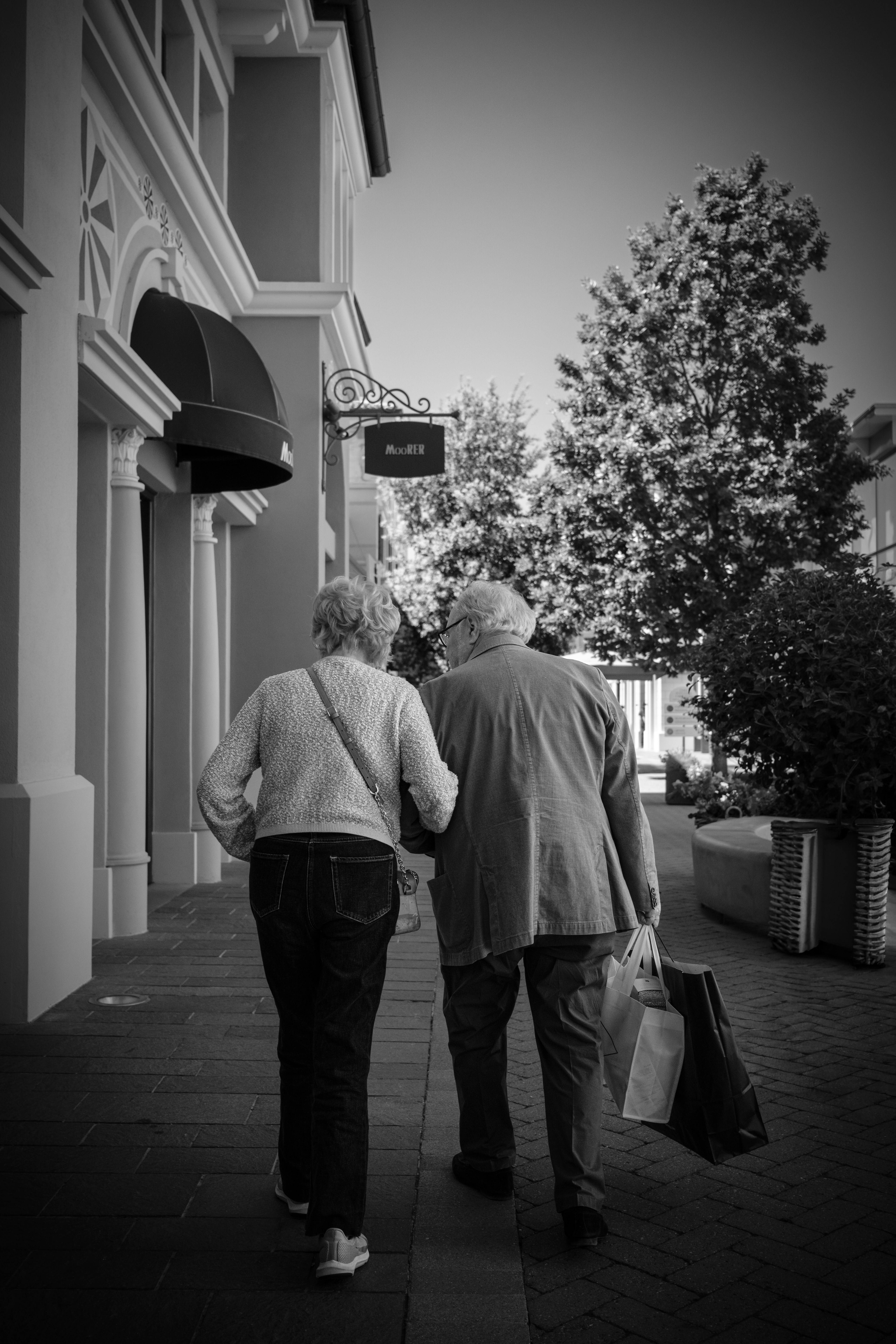 A Quiet Walk: Elderly Couple Leaving the Boutique Street