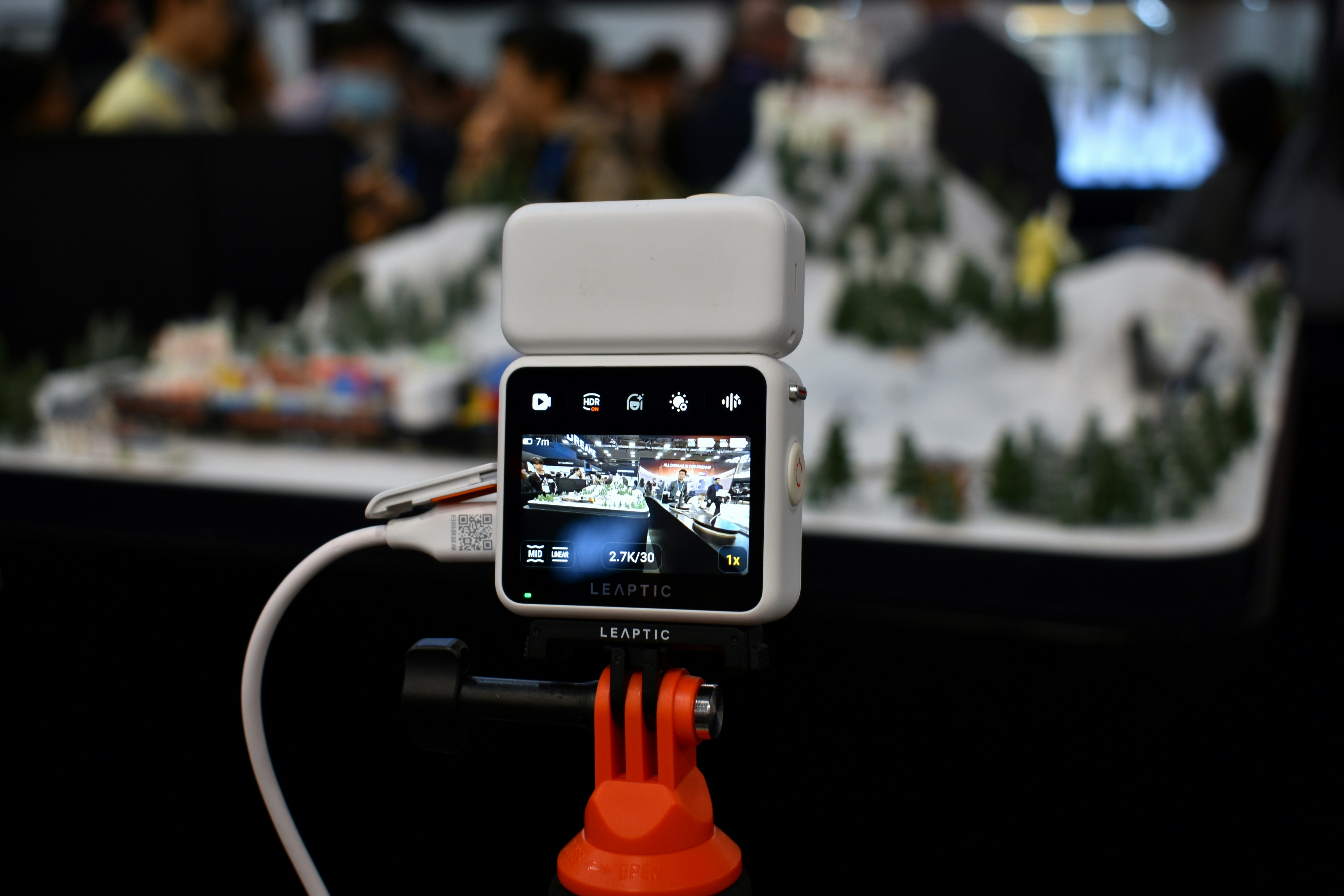 Miniature Stage: A smartphone cam on display towers over a blurred scene