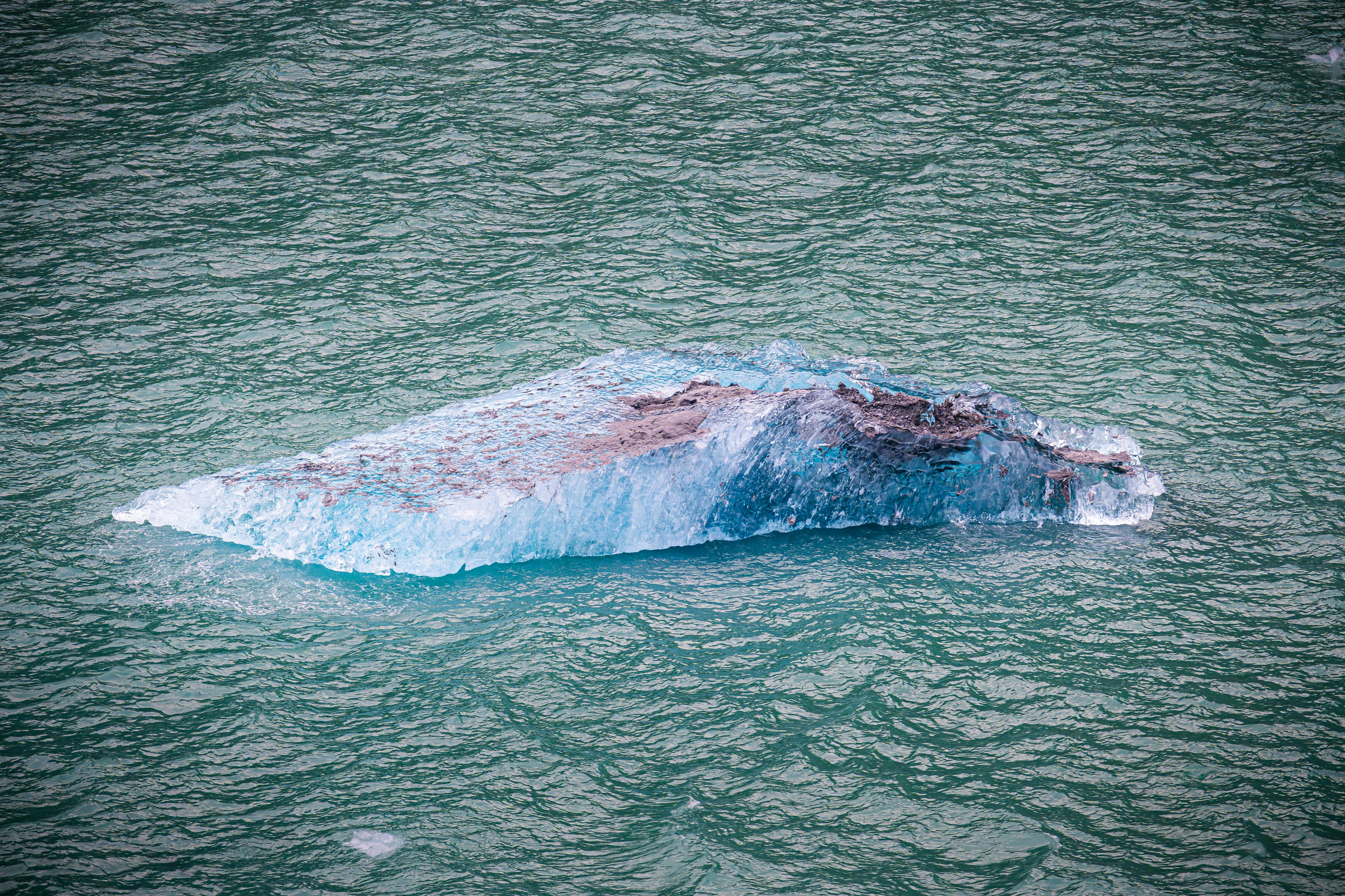 Isolated Iceberg Suspended in Quiet Green Waters