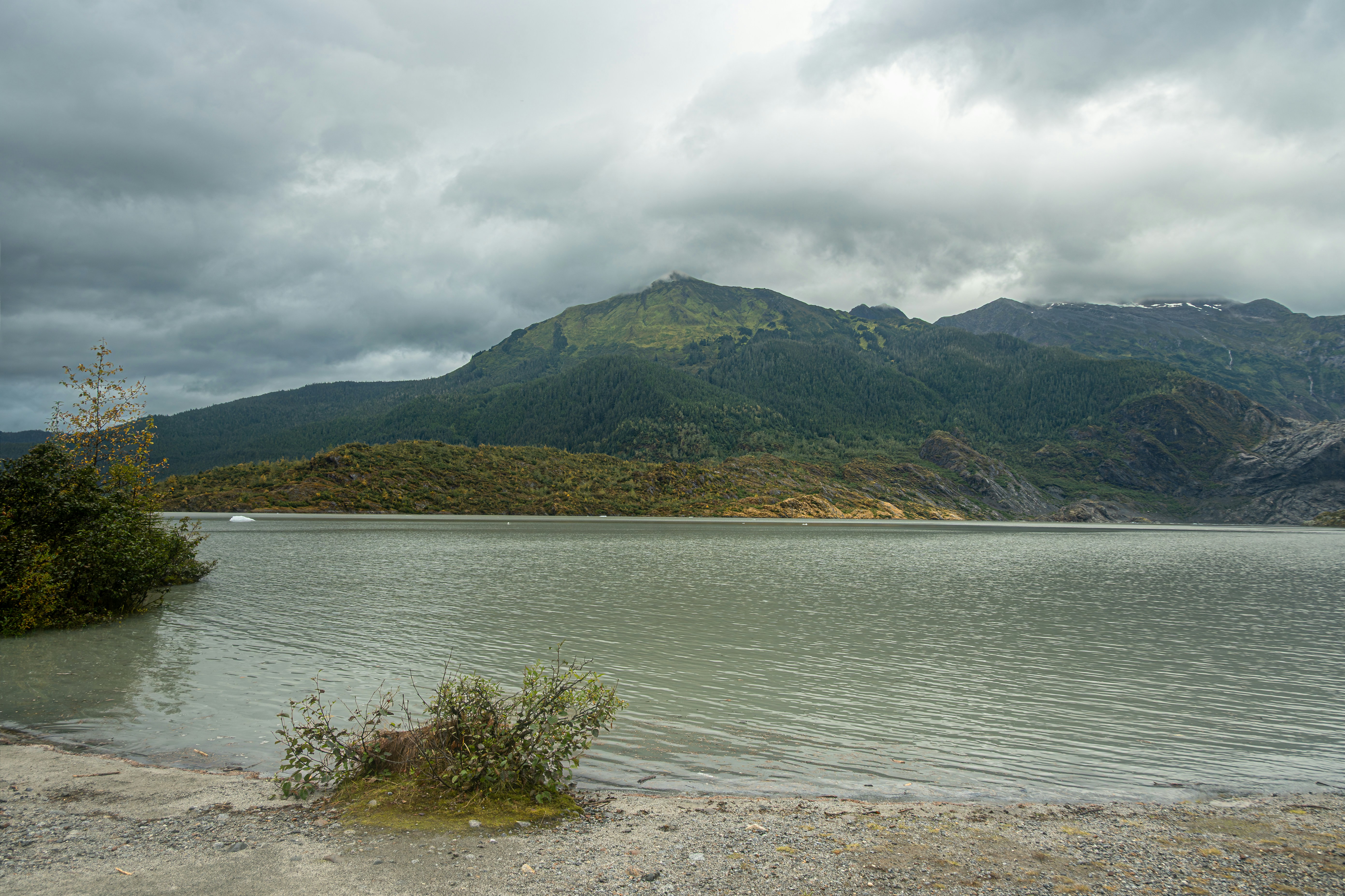 Mountain Rim Over Lake: A Quiet Moment Beneath Stormy Skies