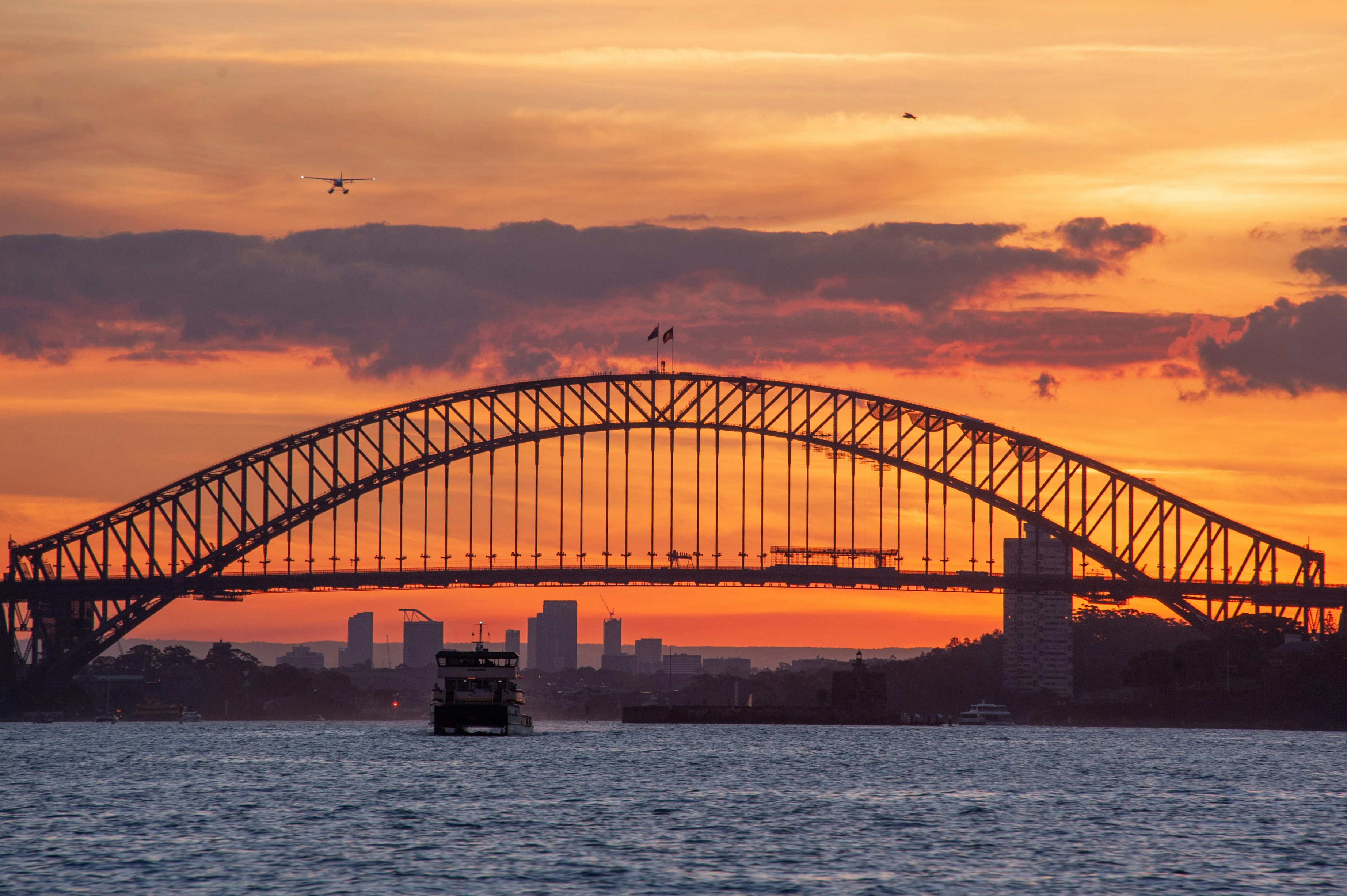Sunset Span: The Sydney Bridge Silhouette Over Calm Waters