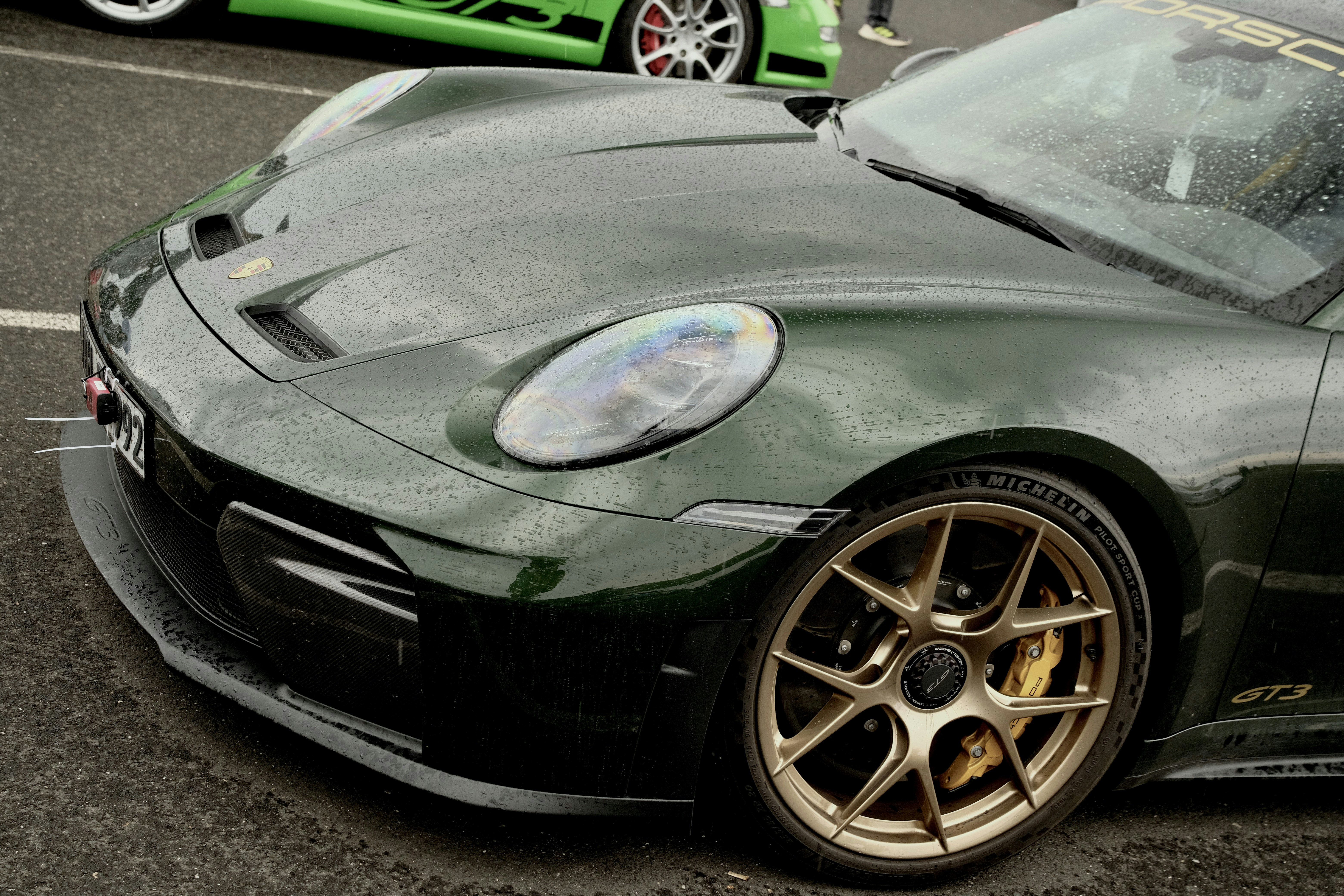 Green Porsche Dawn: A Wet Front-Fender Close with Gold Wheel Detail