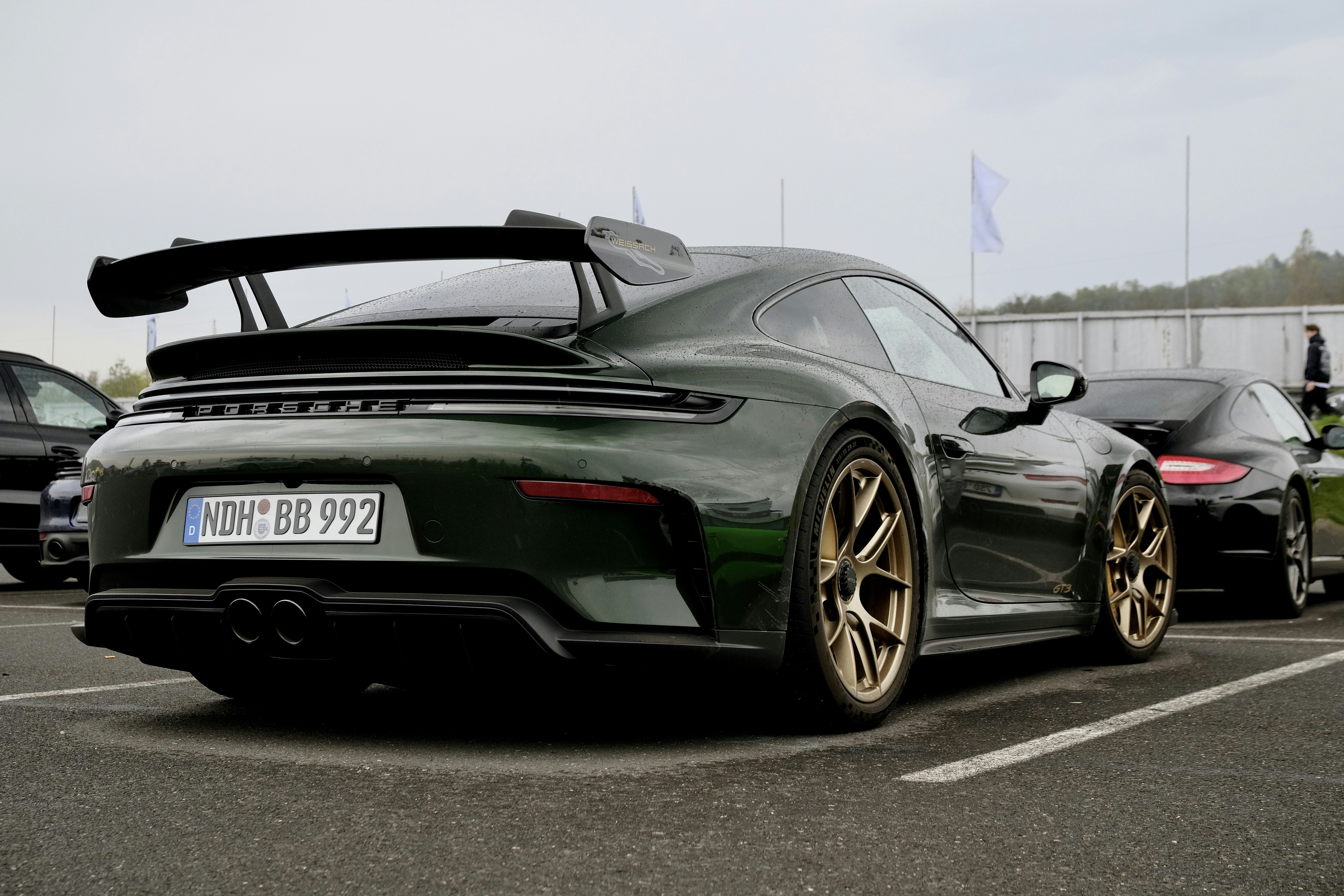 Green Porsche with gold wheels in a car meetup
