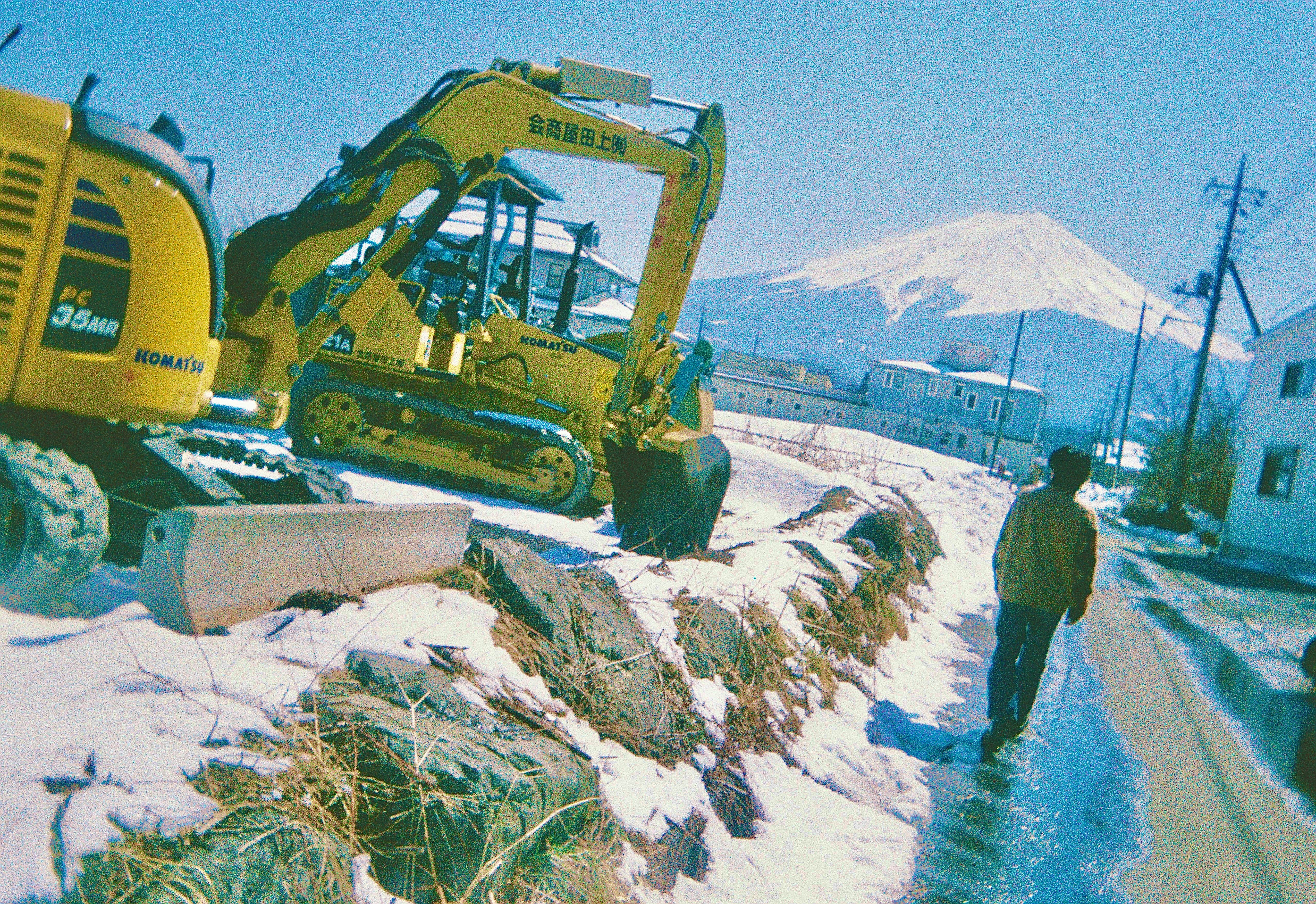 Snowy Construction Street with Machinery under a Mountain