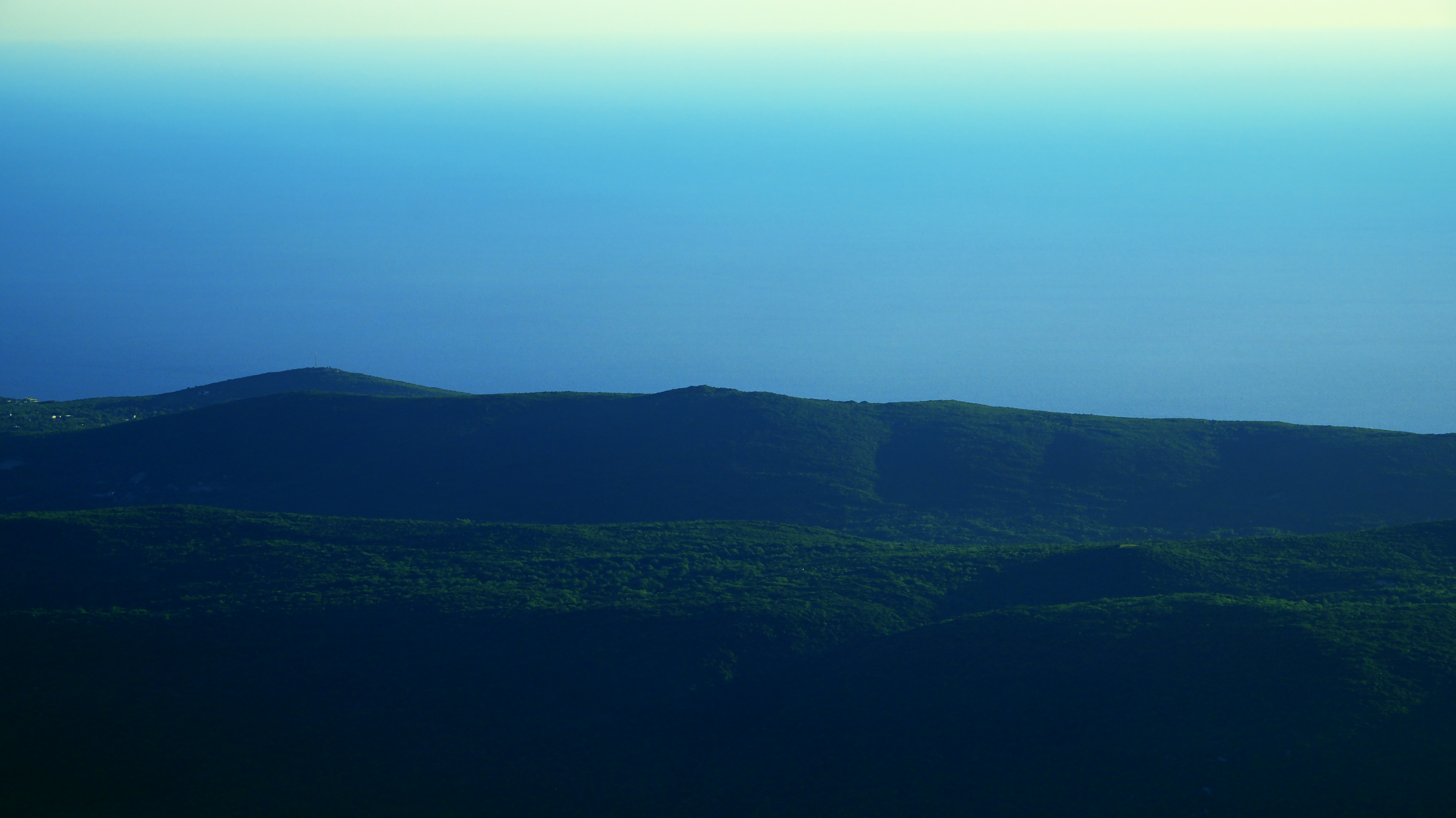 Distant Crest: Coastal Ridge Meeting the Calm Atlantic