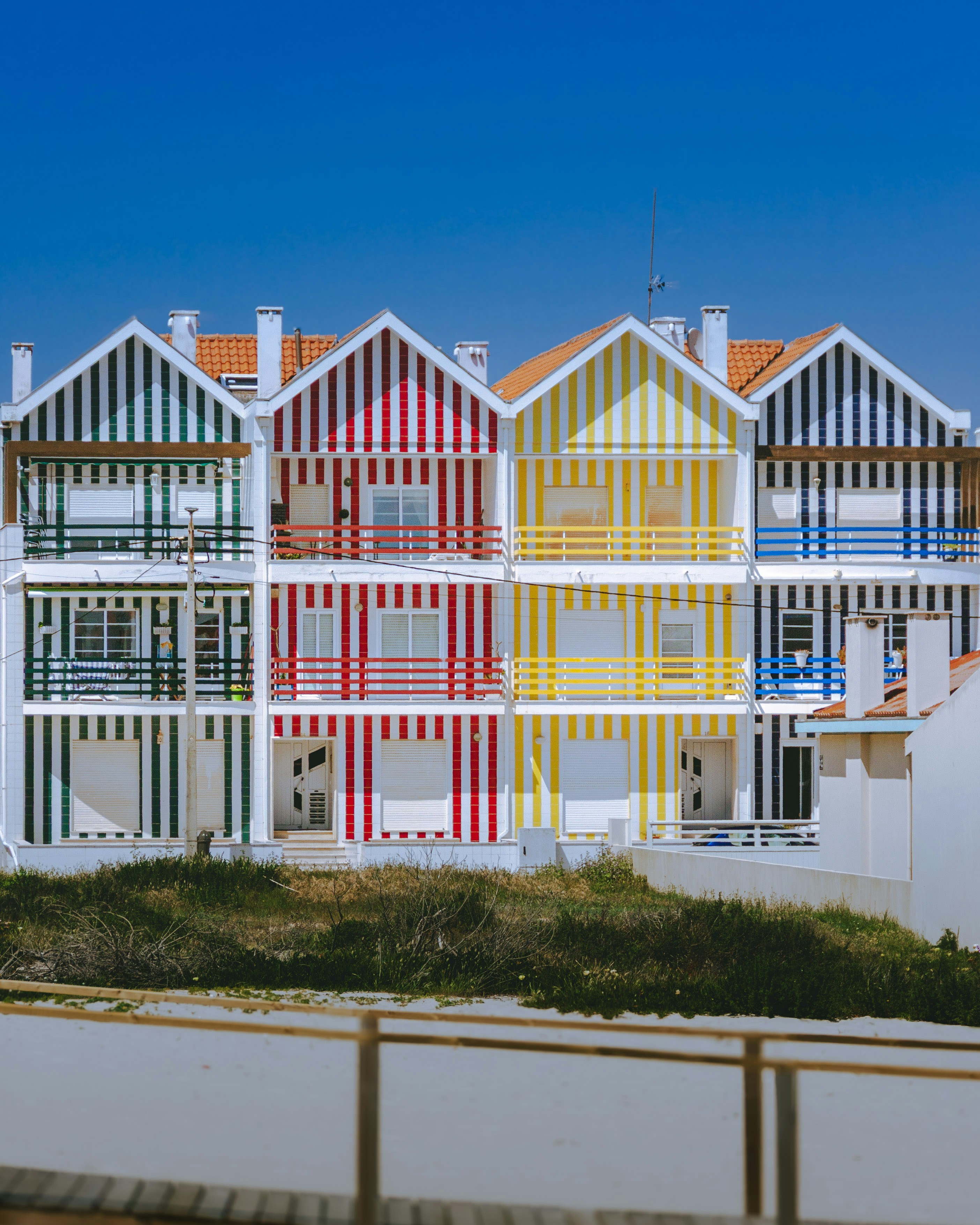 Color Blocked Facades: A Row of Striped Beach Houses