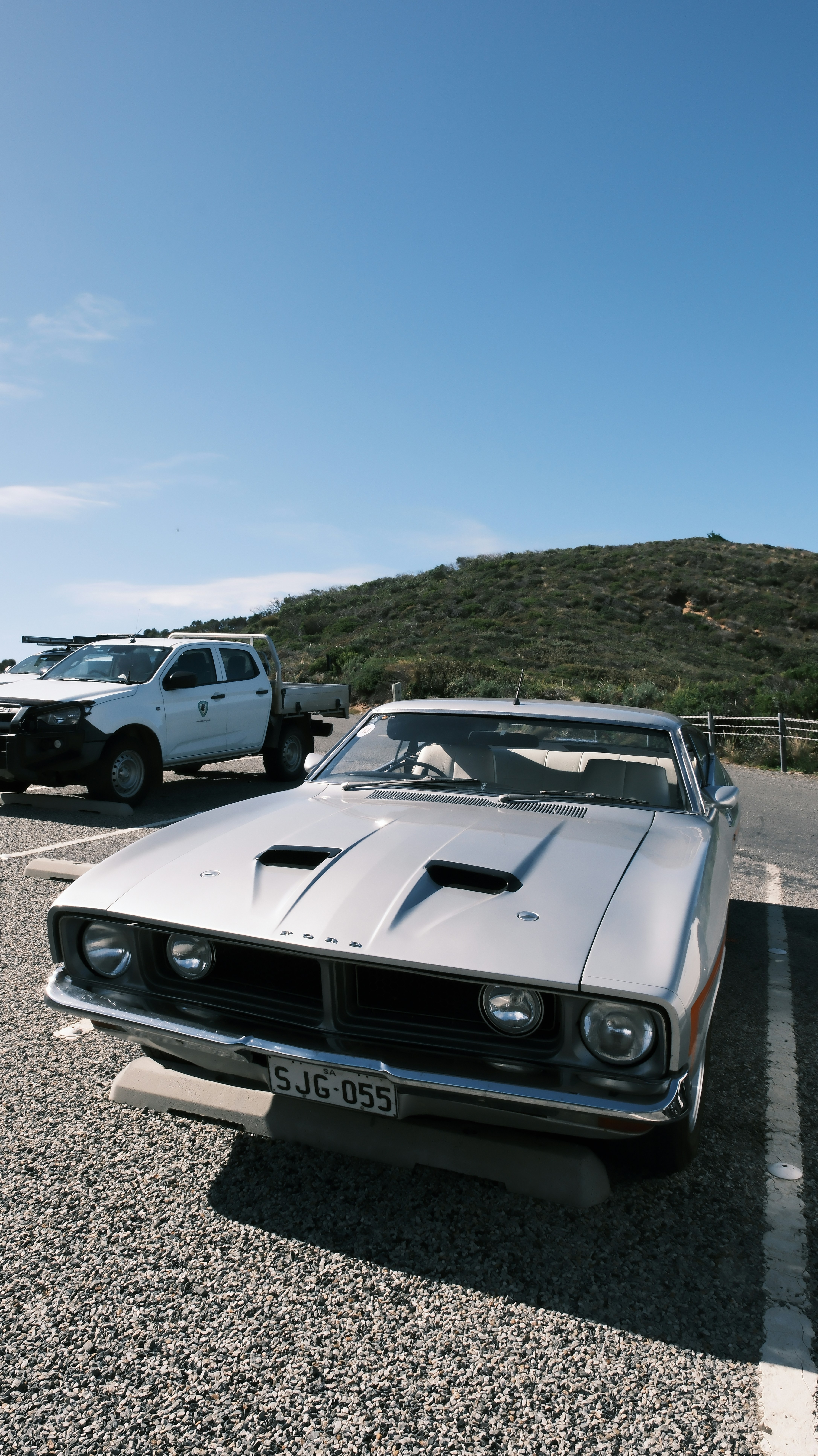 Chrome and Gravel: A Classic Muscle Car at the Edge of the Hill