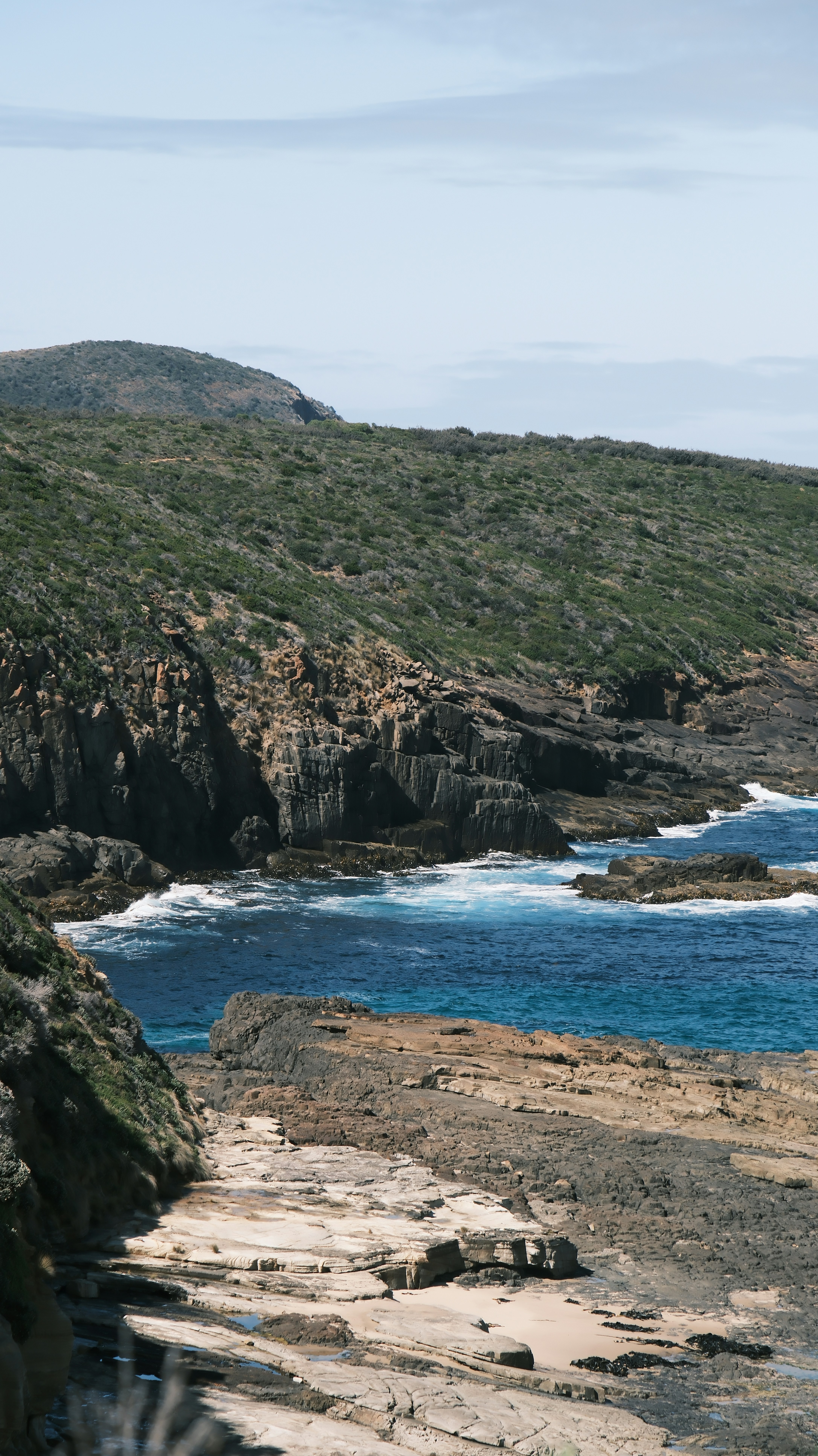 Rugged coastline canyon under a pale blue sky