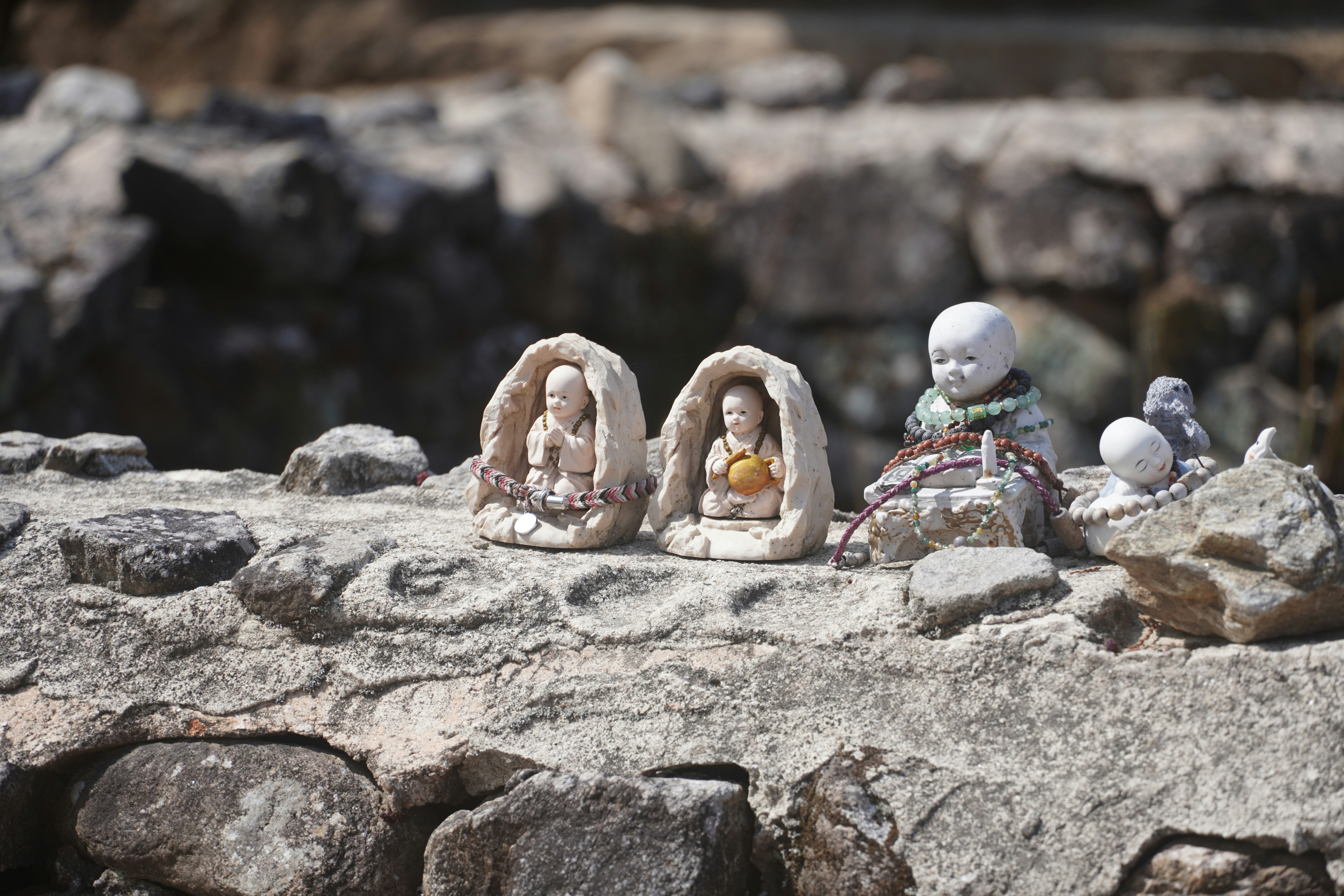 Miniature Figures Amid Rough Stone Toyer: A Quiet Patina of Coastal Rocks