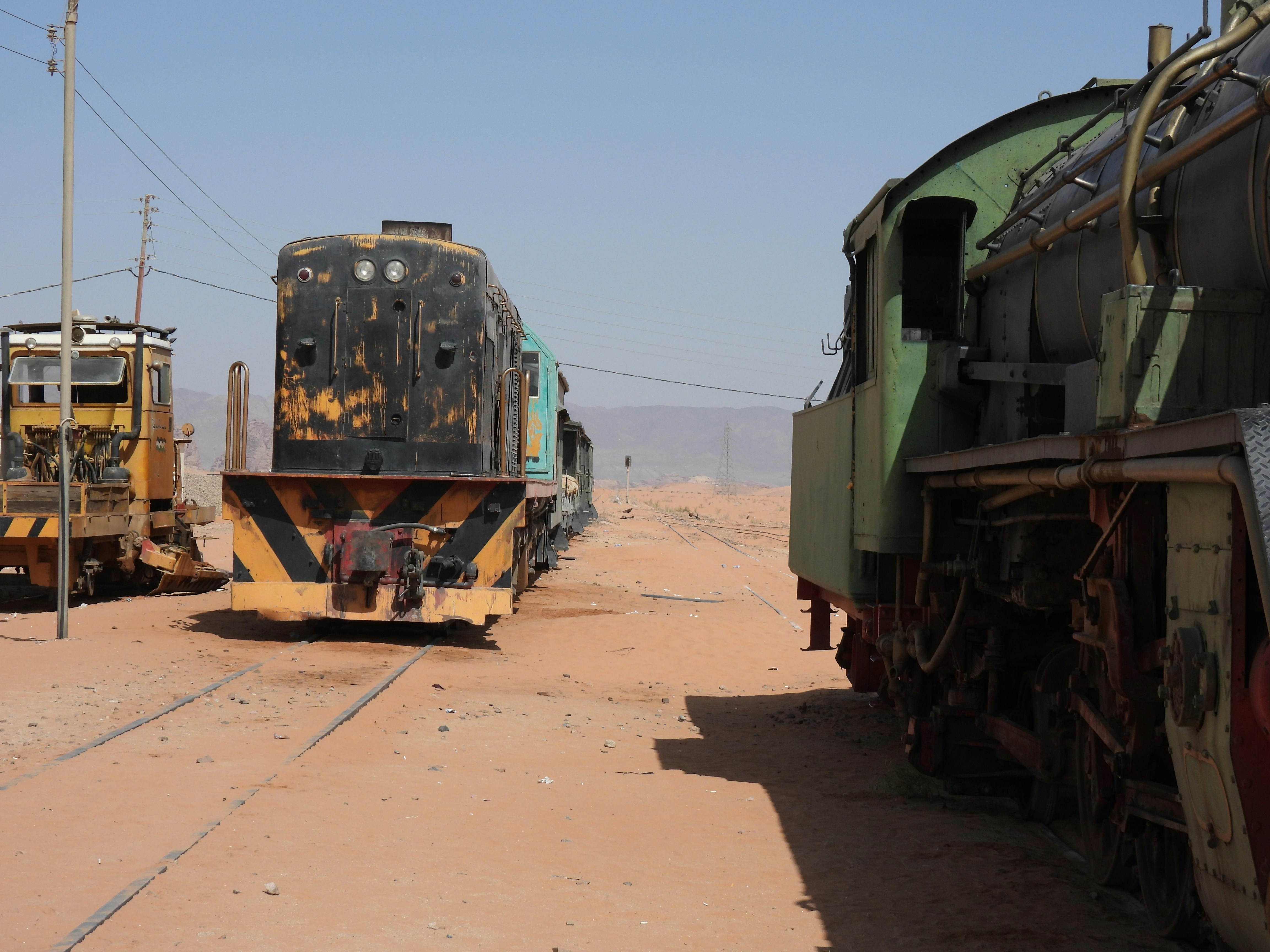 Desert Railyard Portrait: A Line of Weathered Locomotives in Dunes