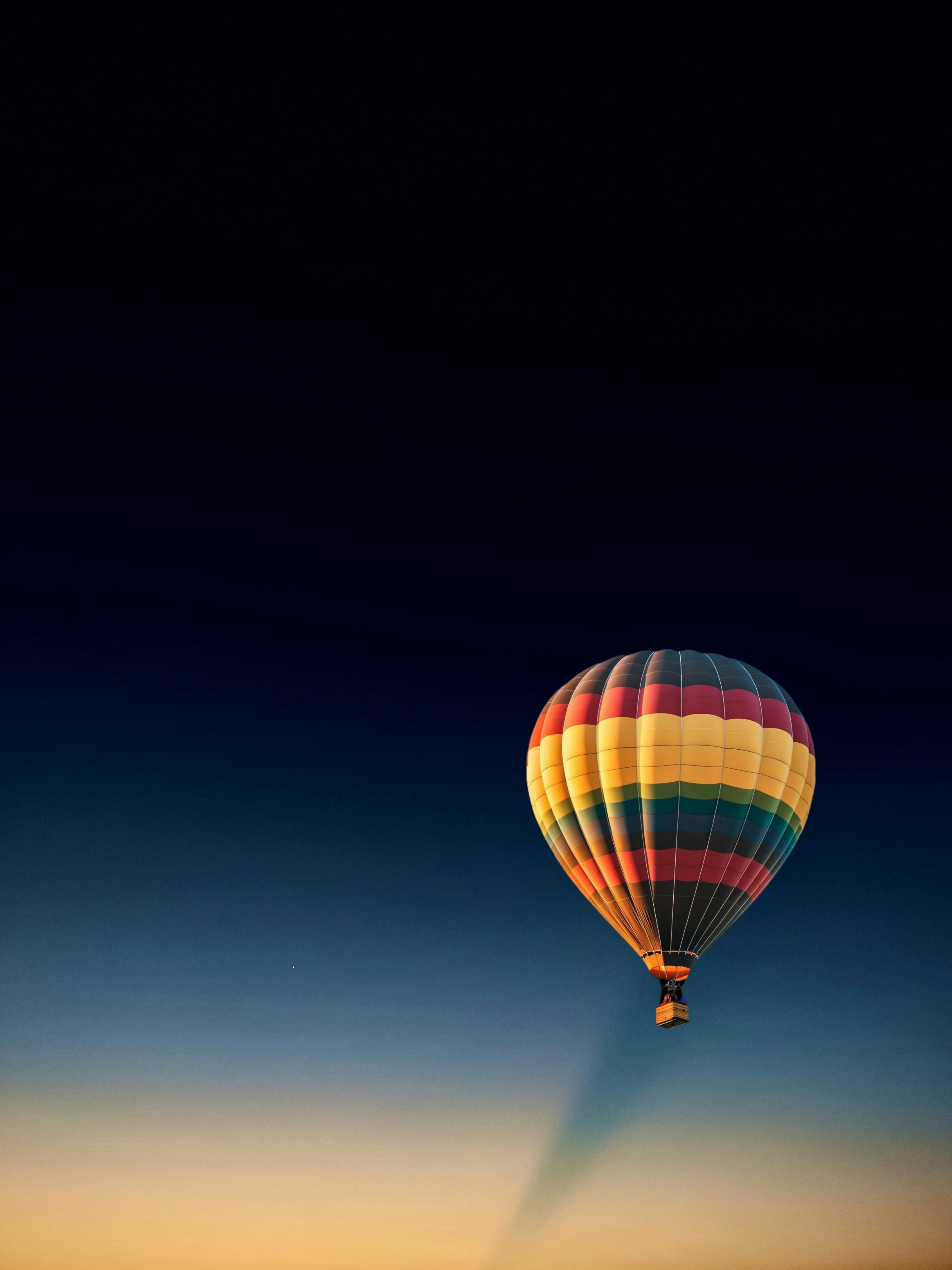 Floating Prism: A Rainbow Balloon Soars Above the Dusk Horizon