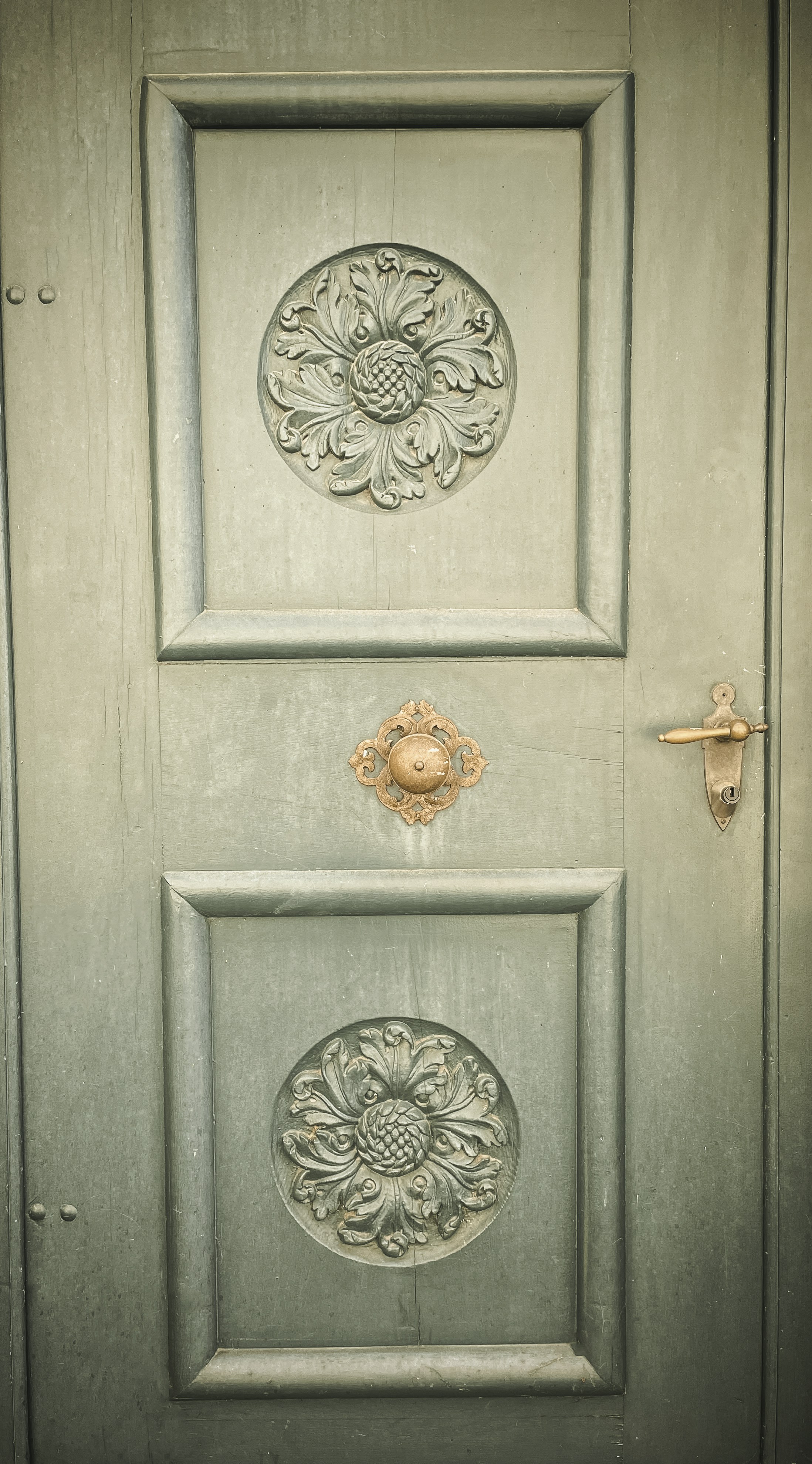 Ornate Door Panel: A Weathered Green Welcome