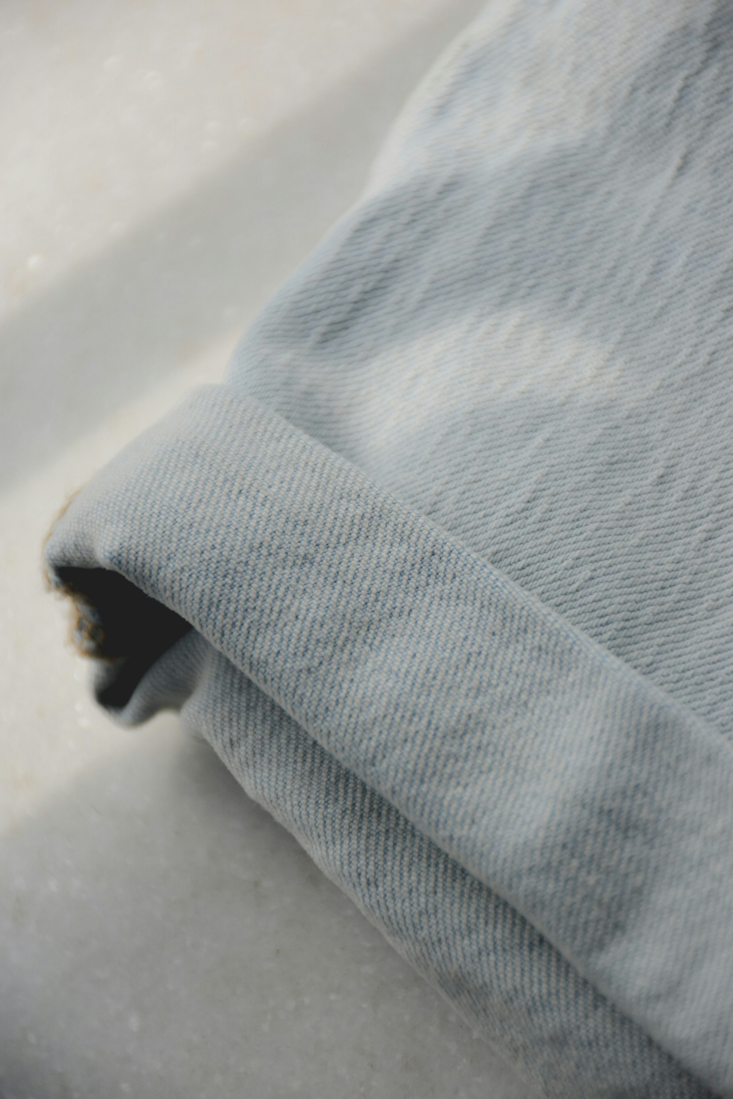 Folded Denim on Soft Marble: A Quiet Textile Moment