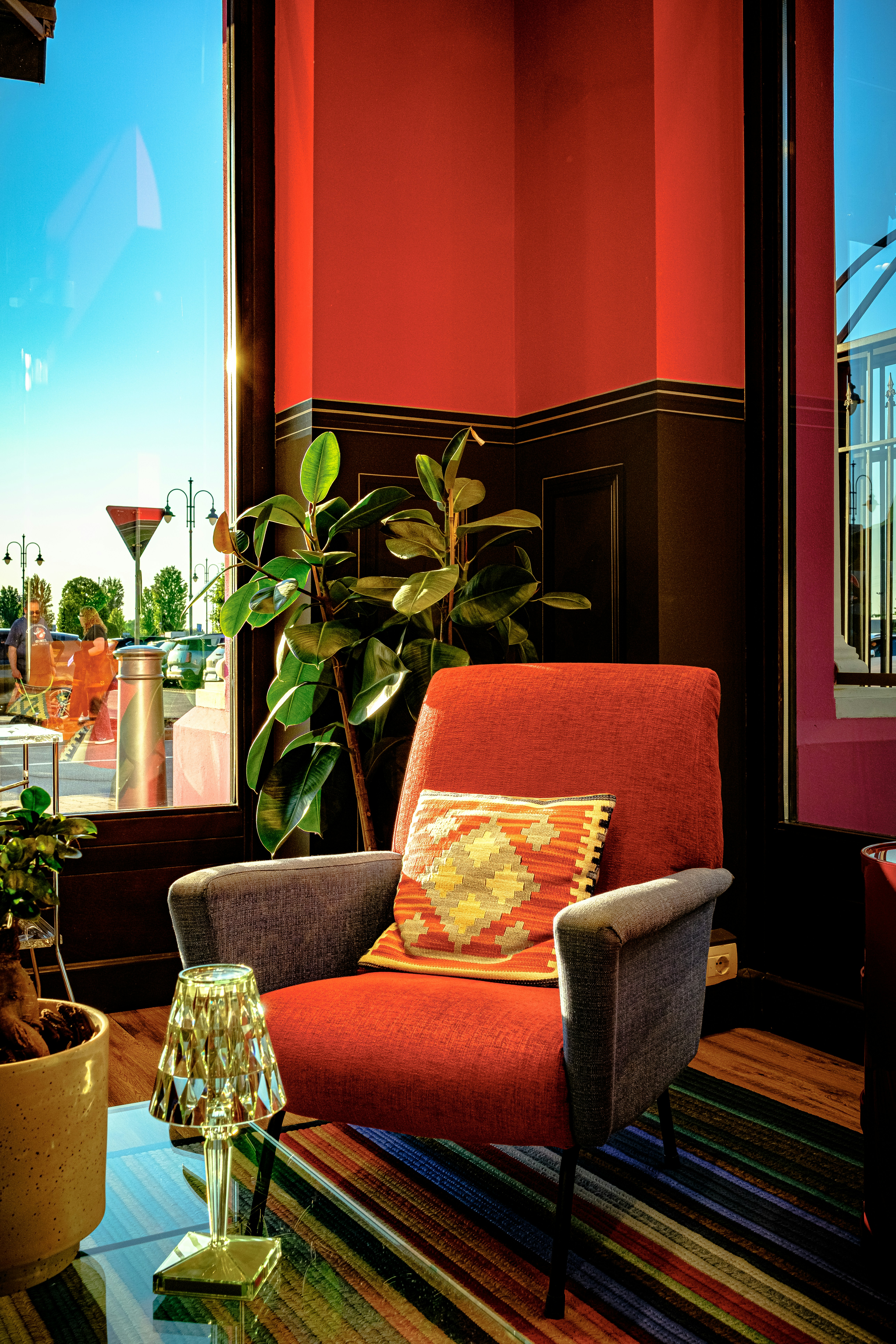 Cozy Corner with Red Armchair and Lush Plant Soaking in Sunlight