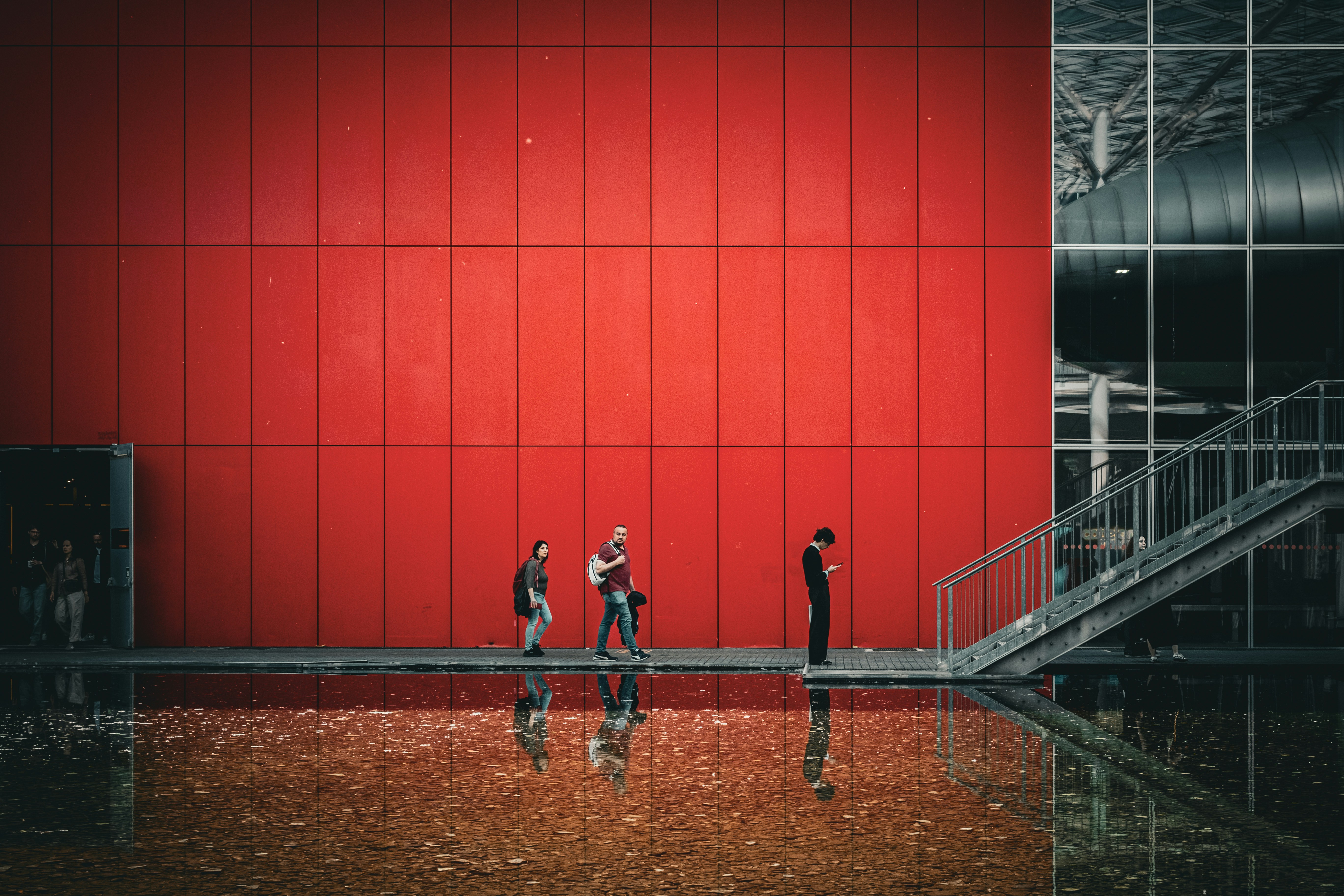 Red Facade, Quiet Steps: A Minimal Moment by the Water