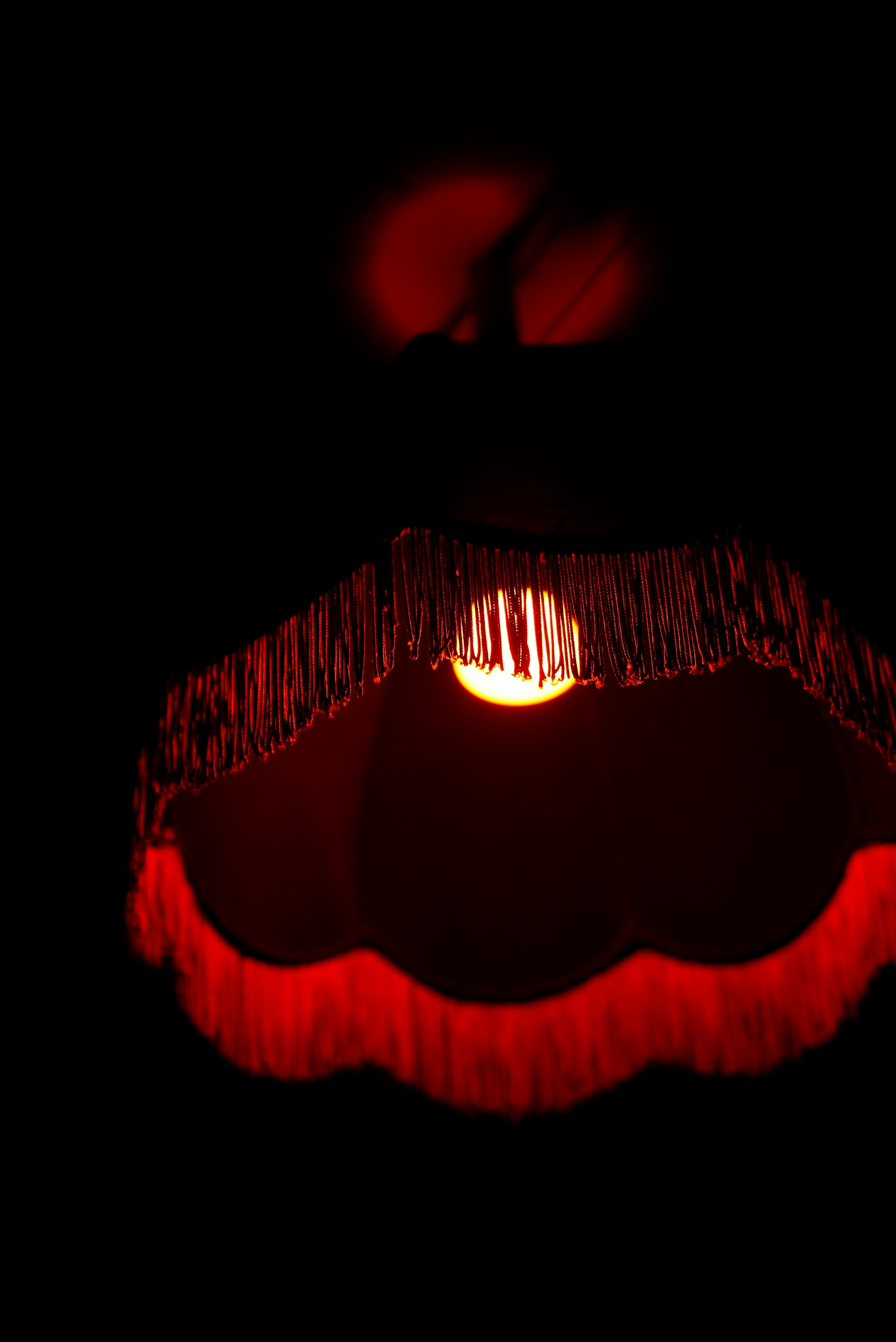 Crimson Fringe: A Shadowed Lampshade Glow