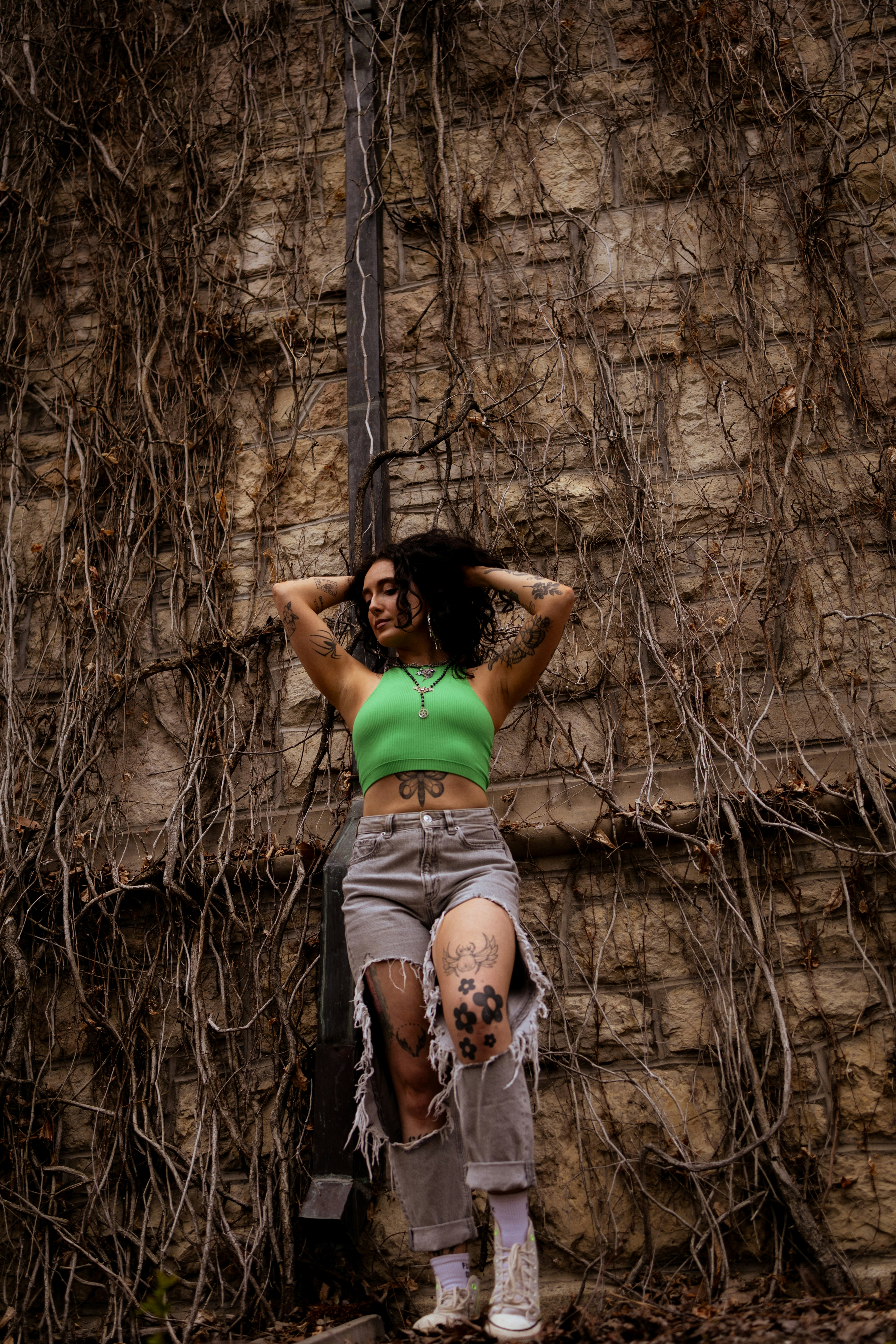 Urban vines and green centerpiece: a confident portrait against a tangle of roots