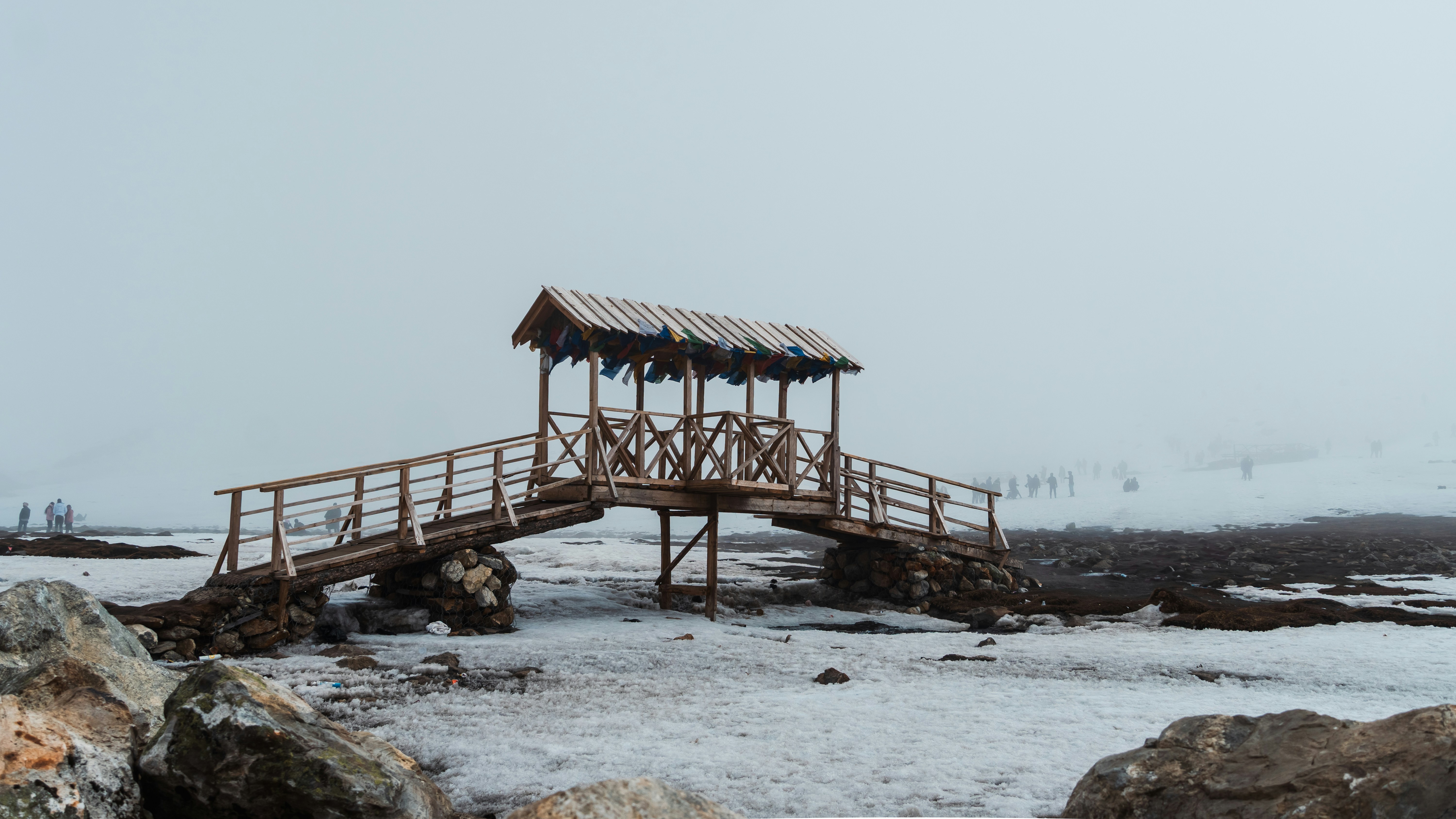 Wooden Viewing Platform Braced by Mist on a Snow-Dusted Shore