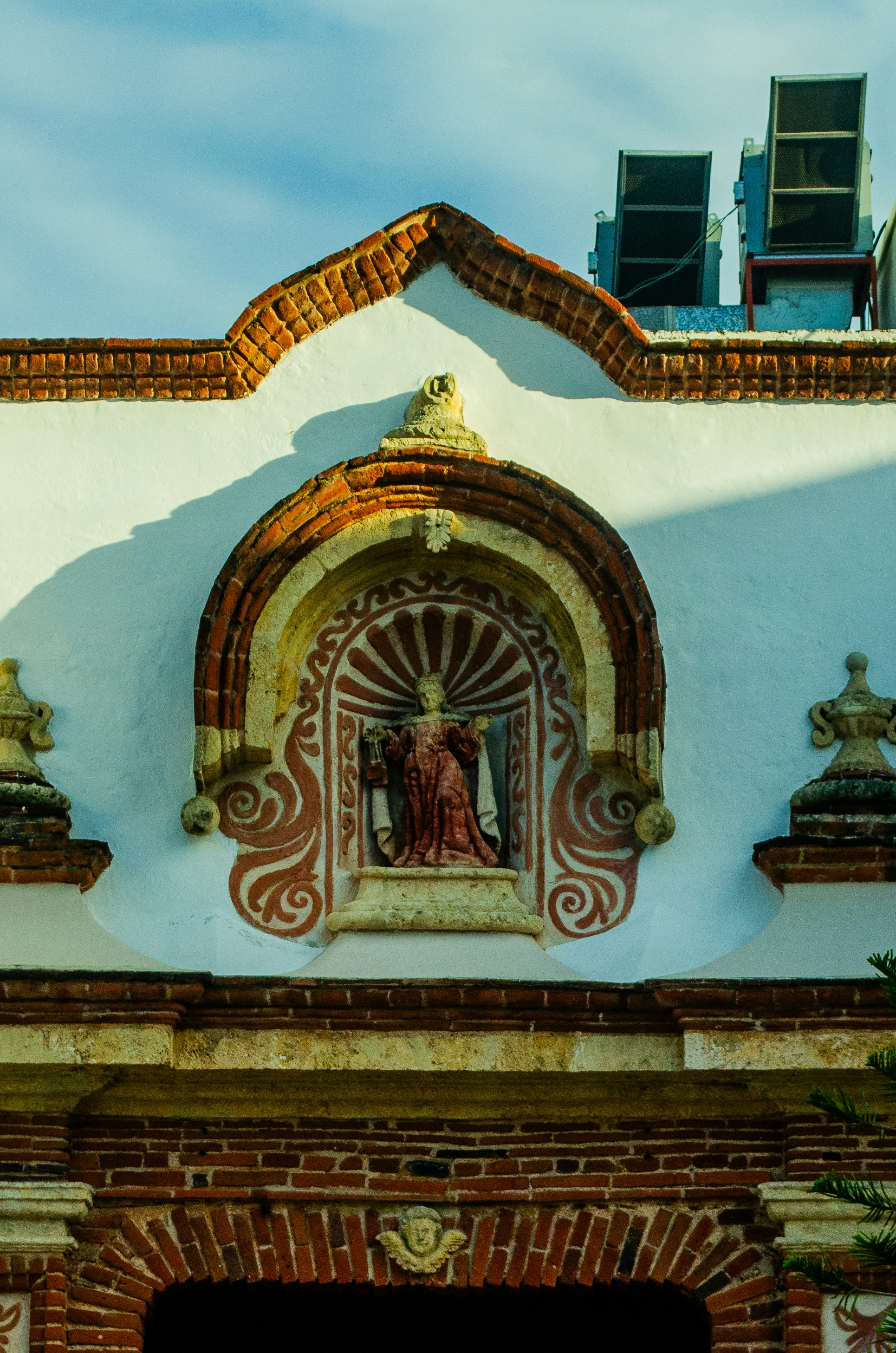 Archway of a Sacred Fresco: Sunlit Facade with Red Brick Ornament