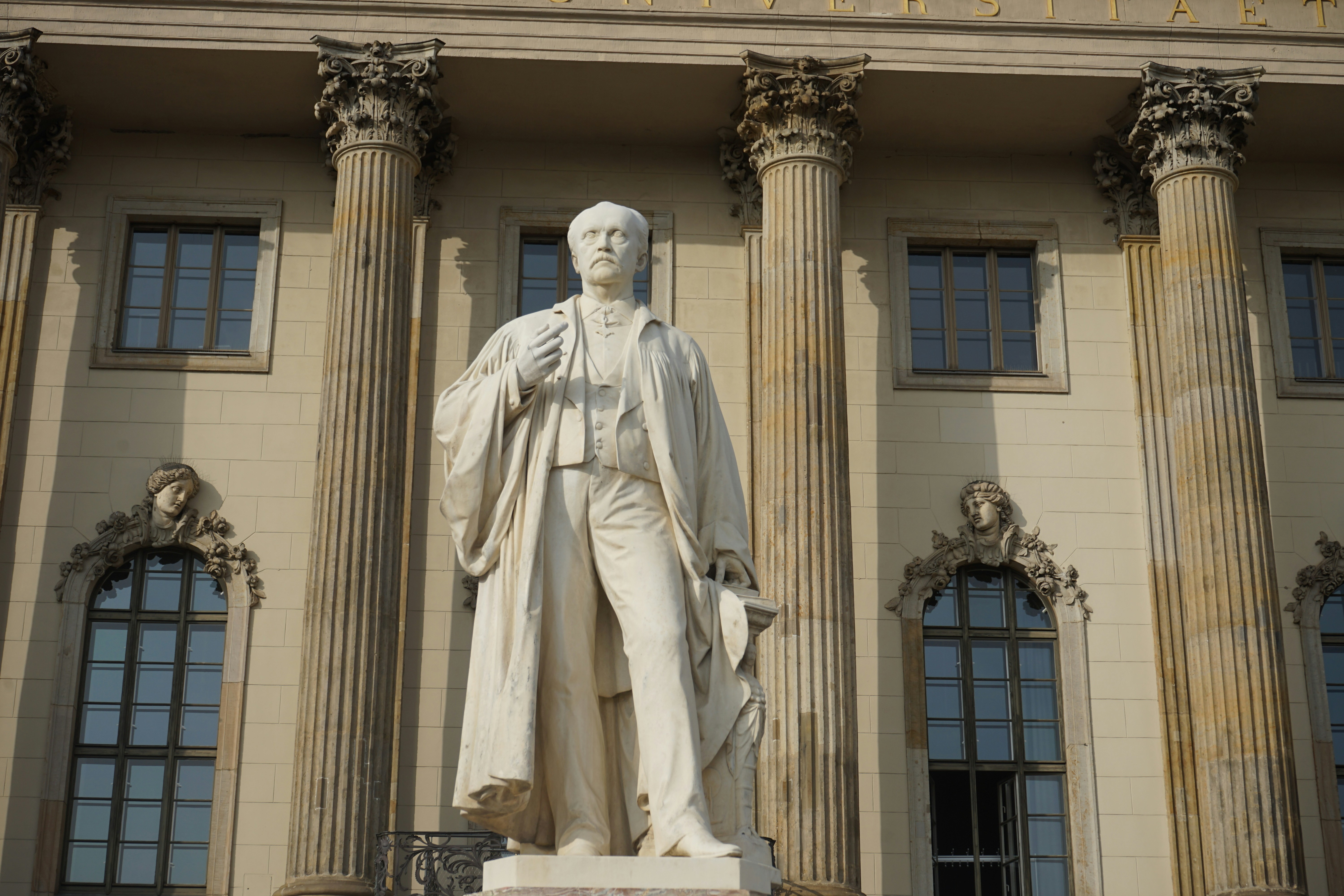 Monumental Emissary: A Classical Statue Anchoring a Neoclassical Facade