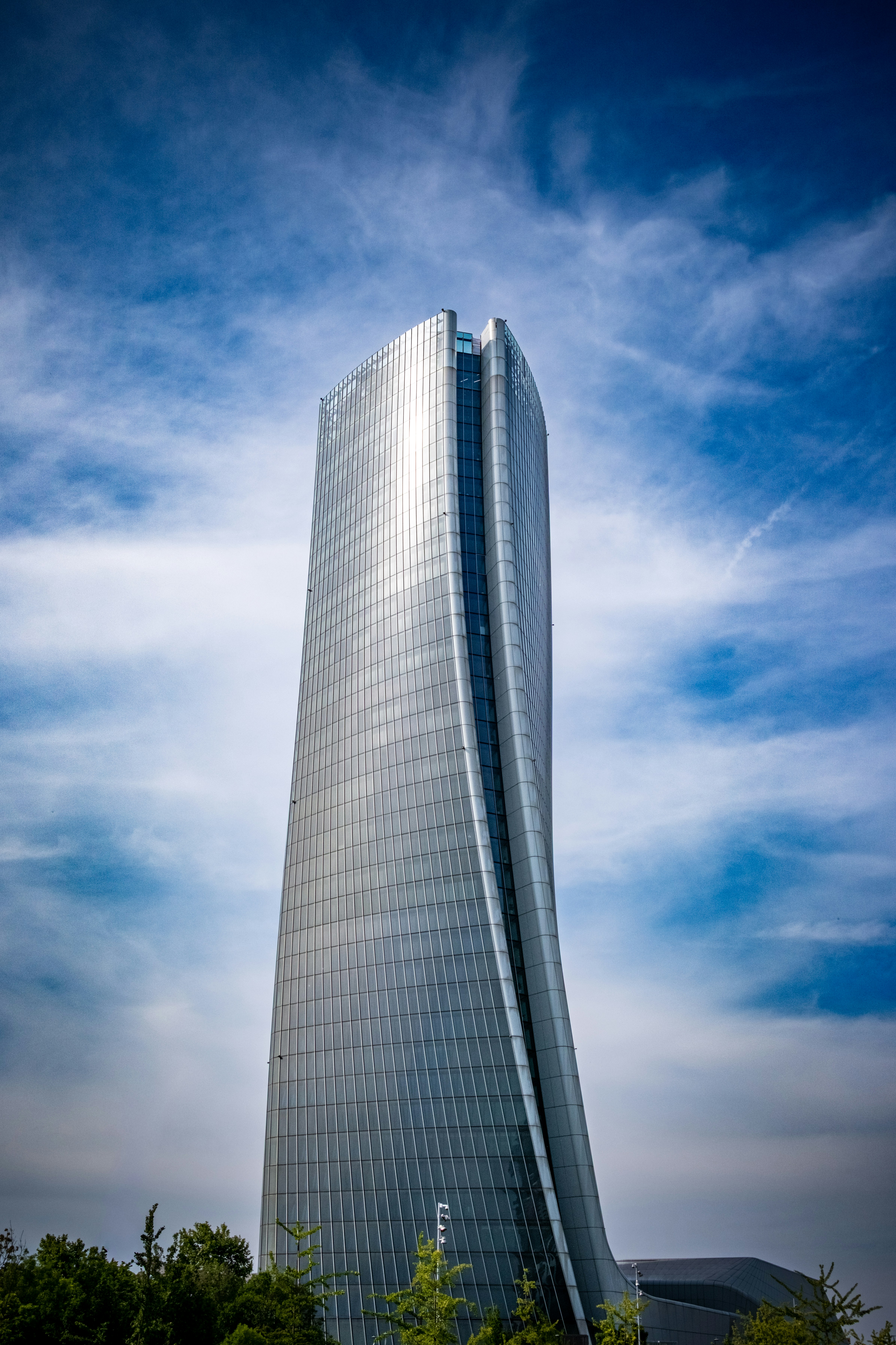 Curved Glass Monolith Rising Above the Park
