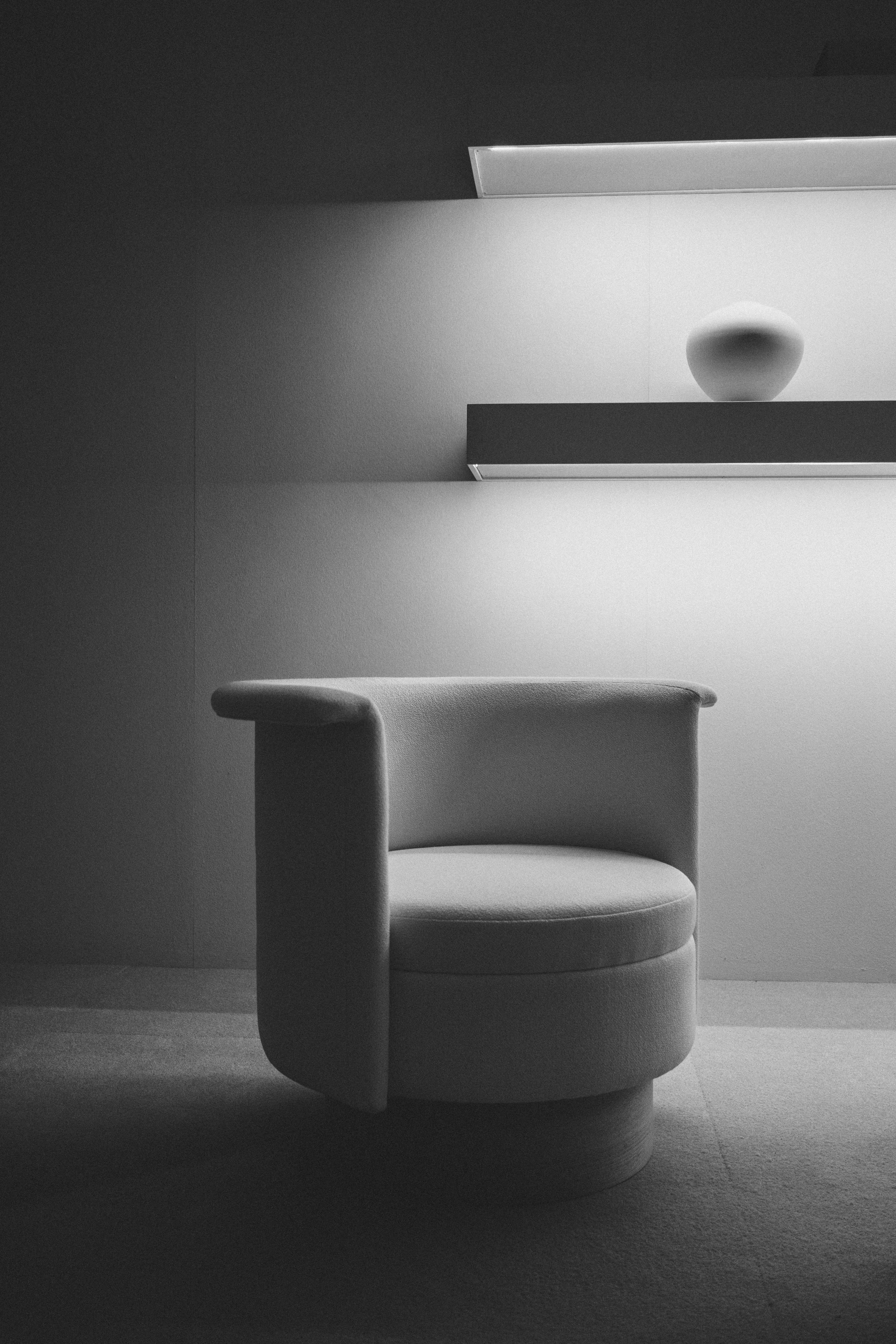 Minimalist Lounge: A Round-Back Chair Under Soft Gallery Light