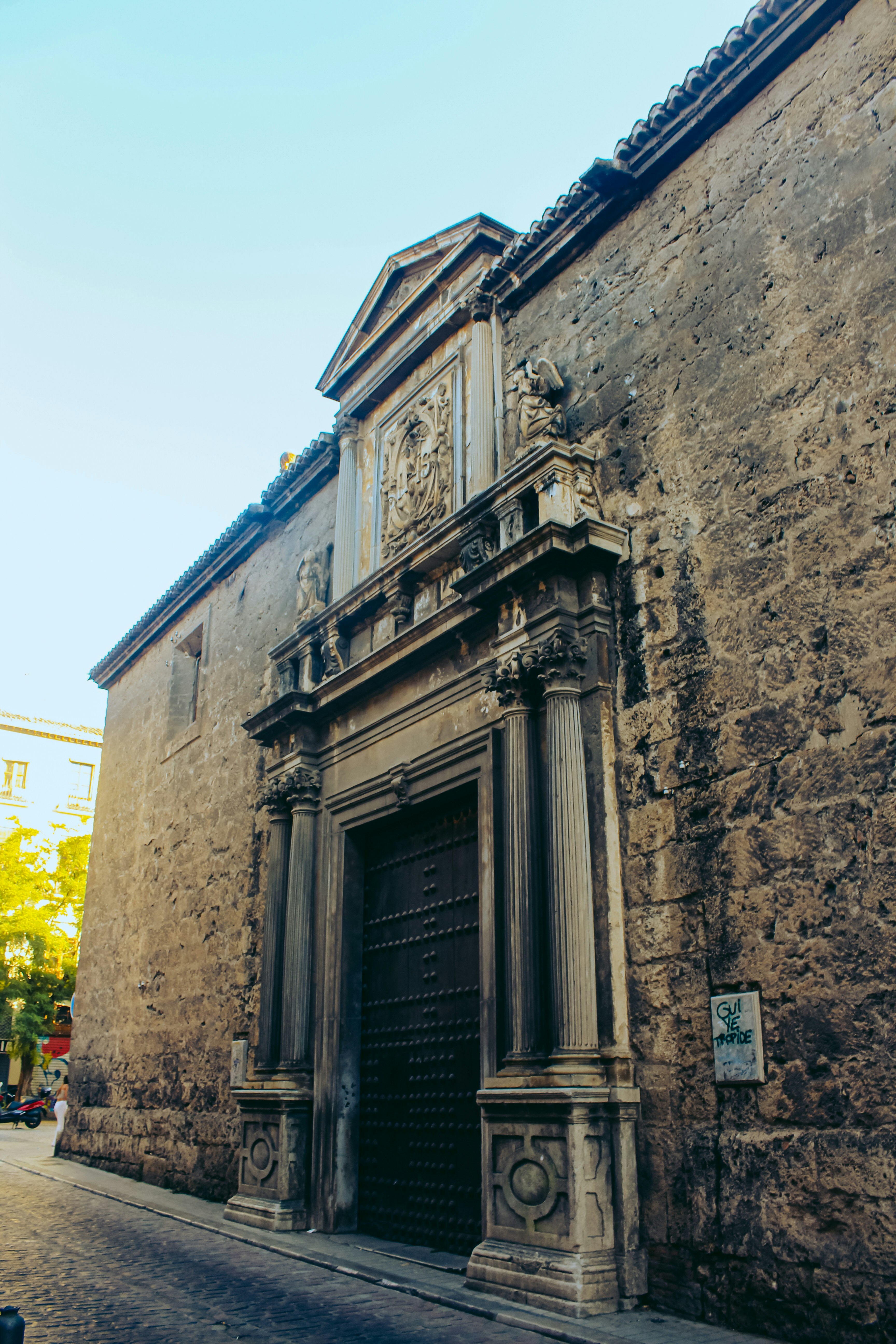 Grand stone doorway rising from sunlit alley